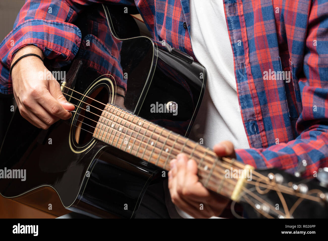 Young man playing guitar, close up view, dark background Stock Photo ...