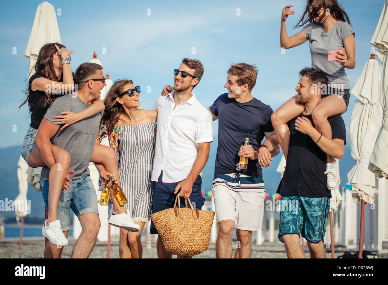 Group of Friends Walking at Beach, having fun, womans piggyback on mans ...