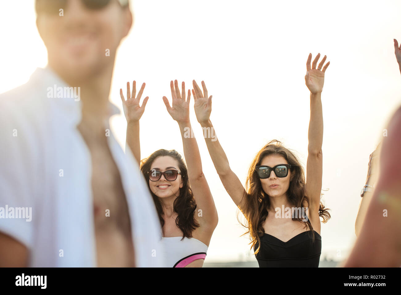 Friends dance on beach under sunset sunlight, having fun, happy, enjoy ...