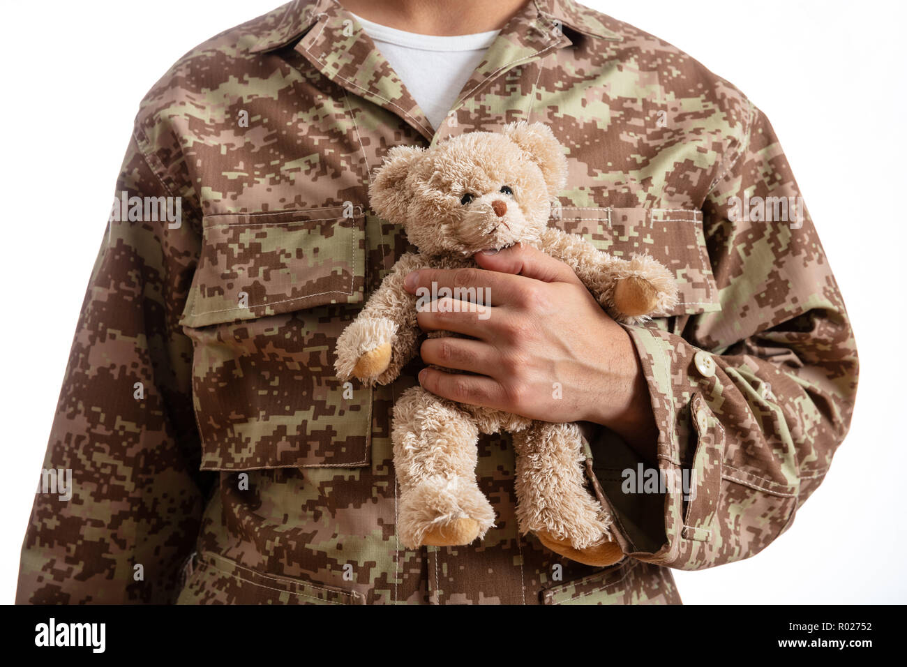 Father in the Army. Young soldier holding a teddy bear standing on ...