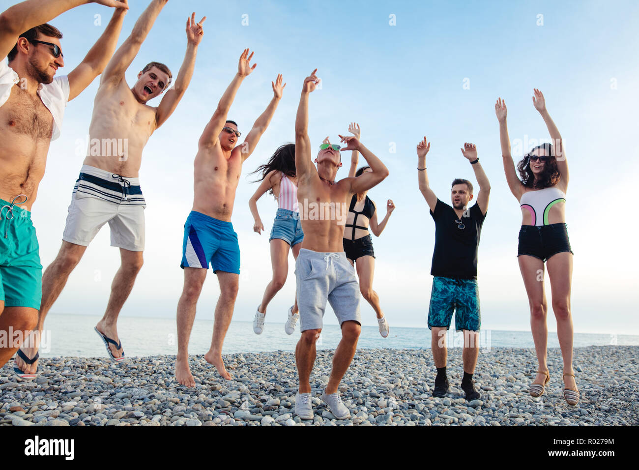 Friends dance on beach under sunset sunlight, having fun, happy, enjoy ...