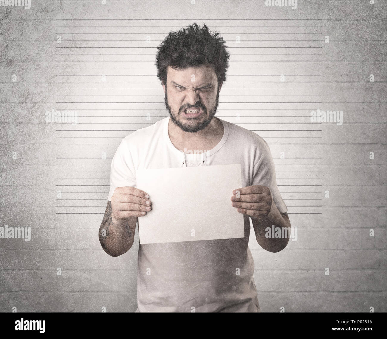 Gangster in front of a wall with table on his hand Stock Photo - Alamy