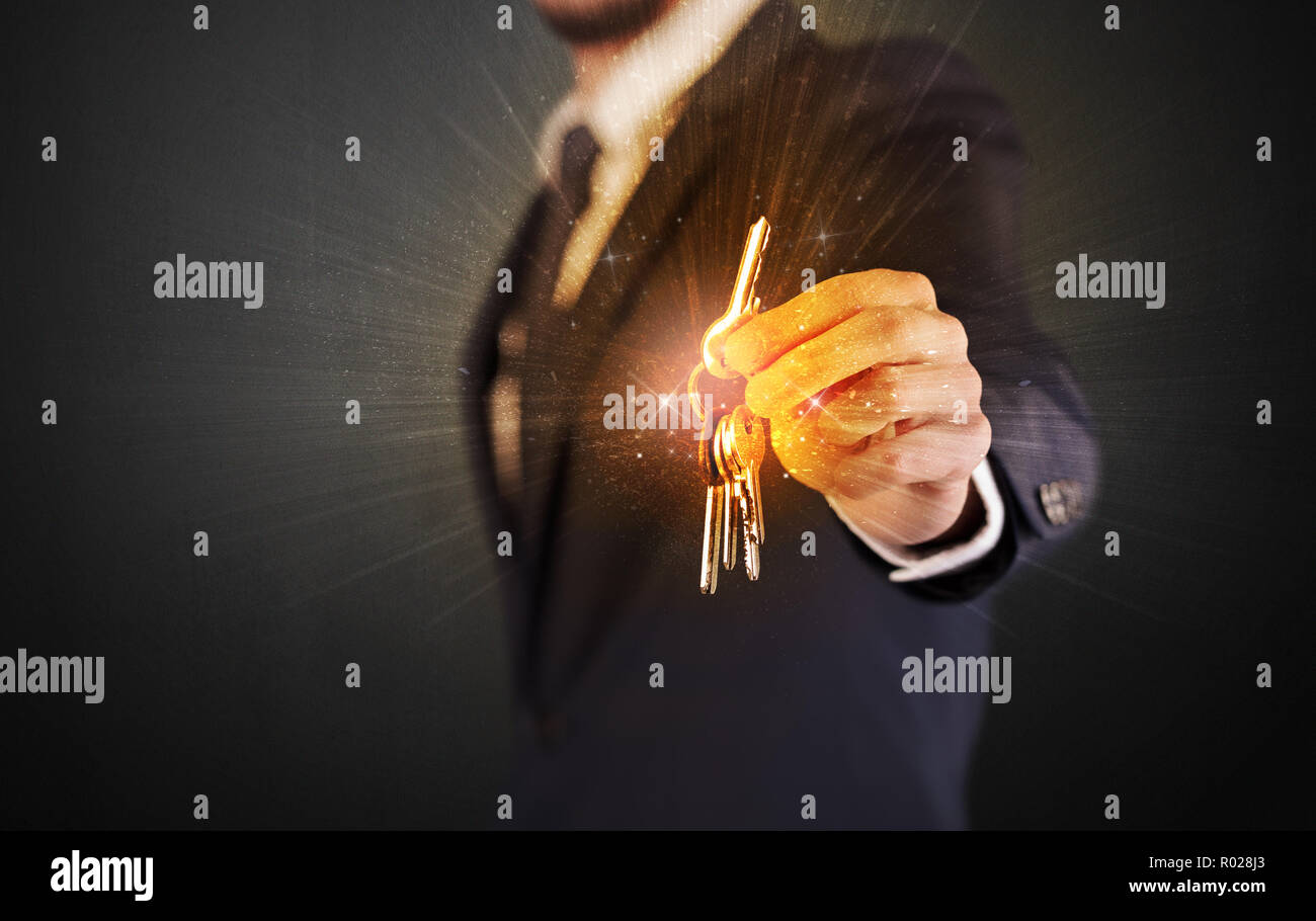 Formal man hand over shiny keys with dark background Stock Photo - Alamy