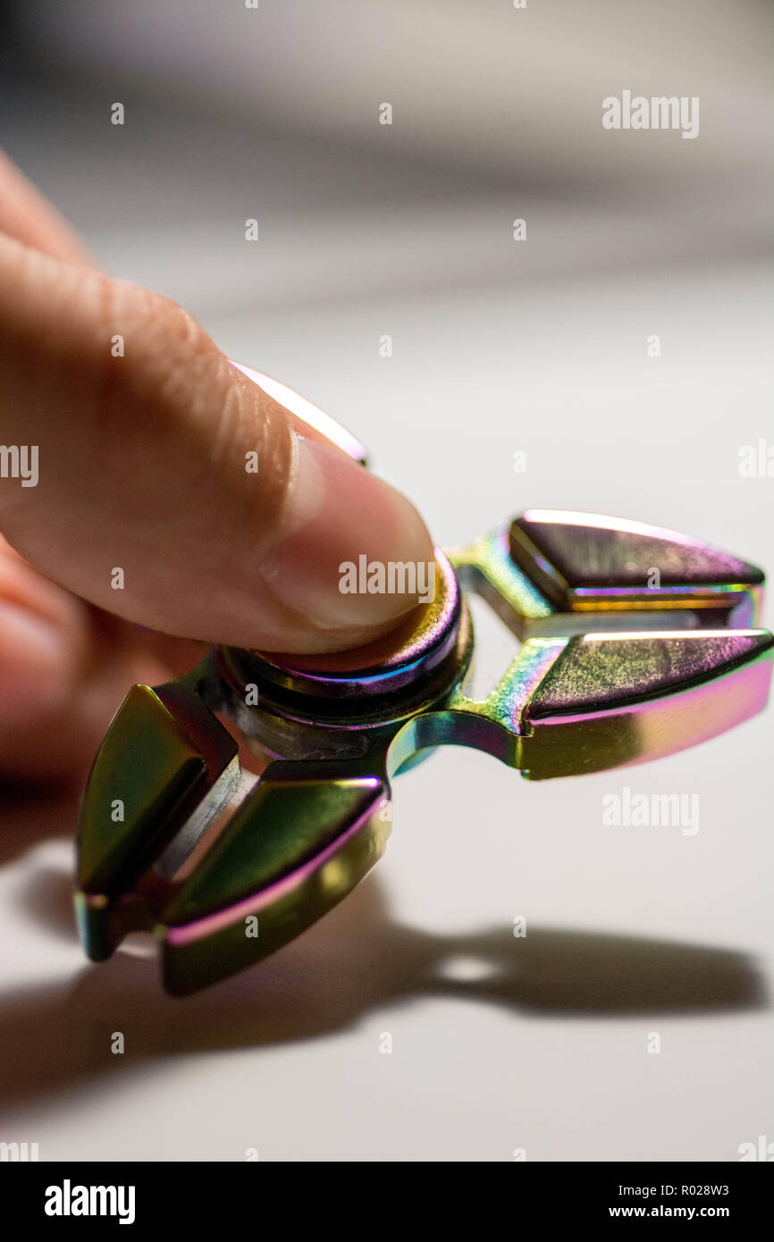 Human hand holding a turning fidget spinner Stock Photo - Alamy