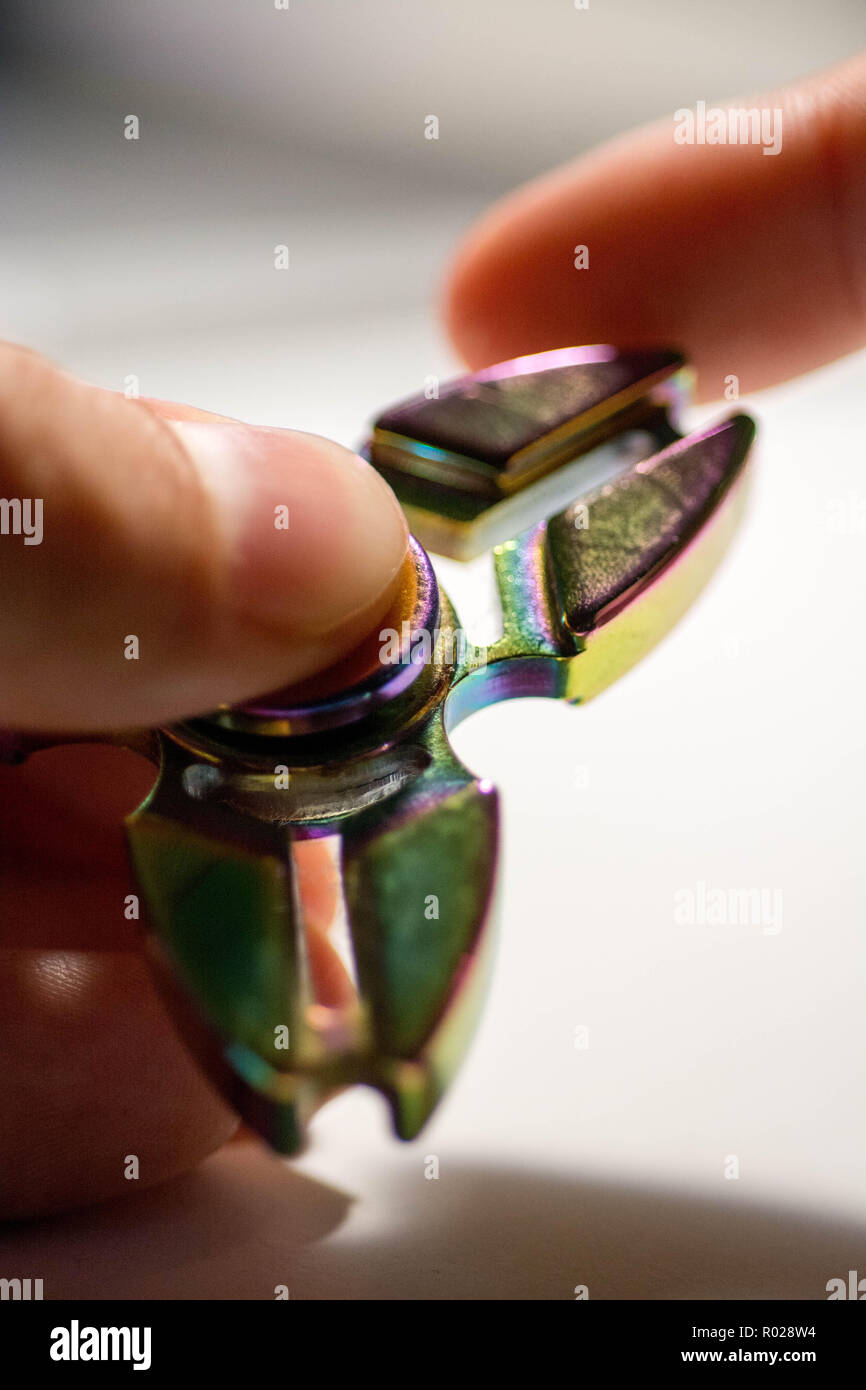 Human hand holding a turning fidget spinner Stock Photo - Alamy