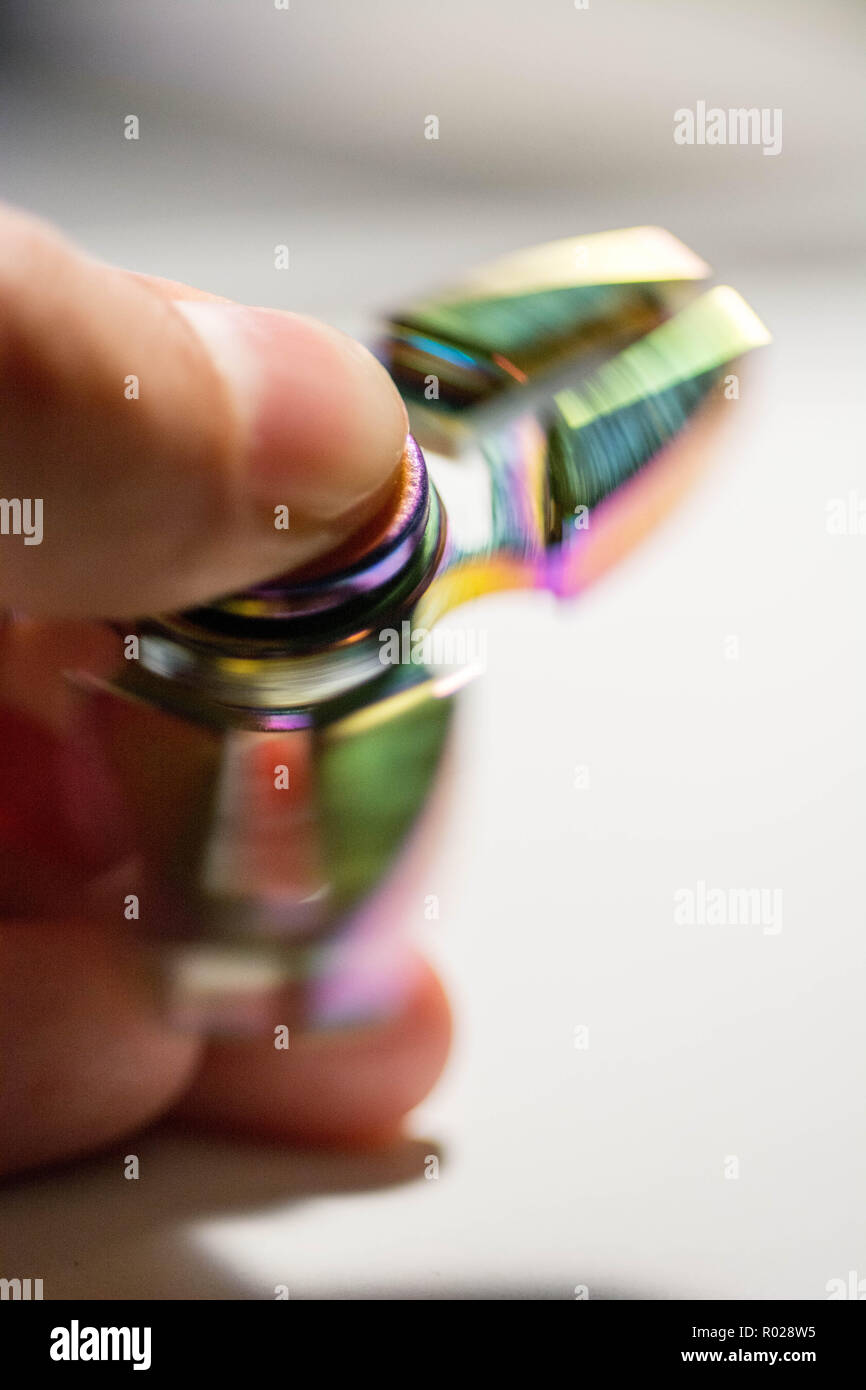 Human hand holding a turning fidget spinner Stock Photo - Alamy