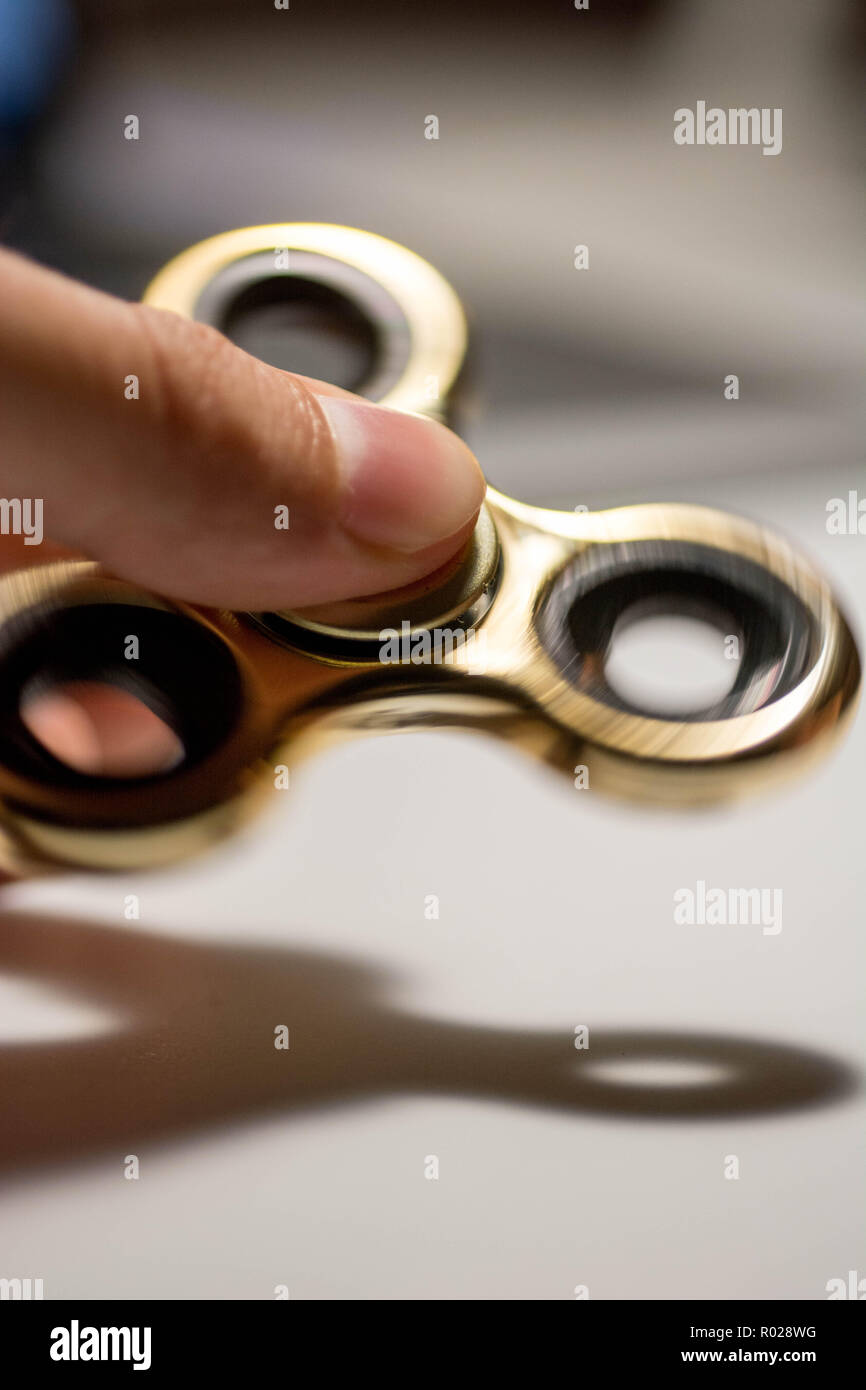 Human hand holding a turning fidget spinner Stock Photo - Alamy