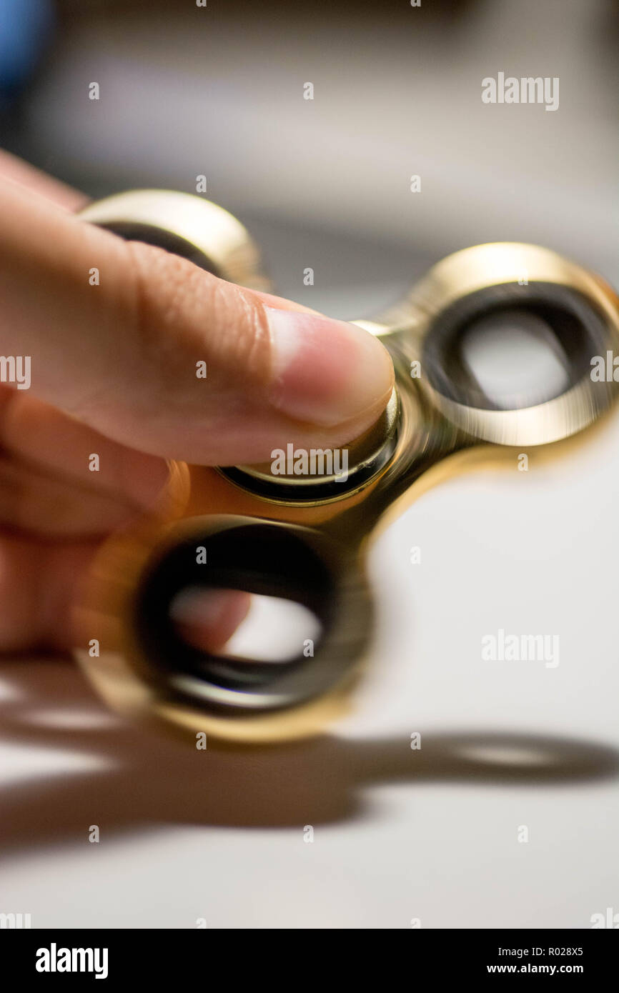 Human hand holding a turning fidget spinner Stock Photo - Alamy
