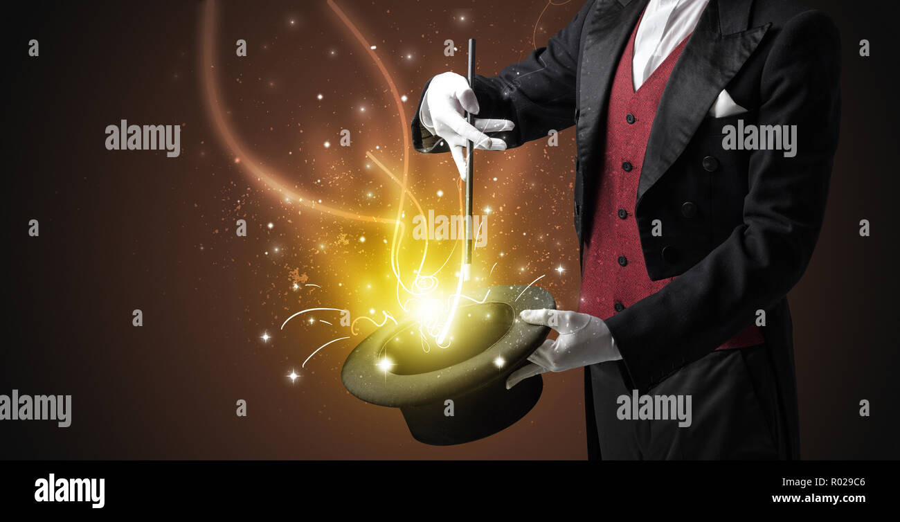 Magician hand conjure with wand light from a black cylinder Stock Photo ...