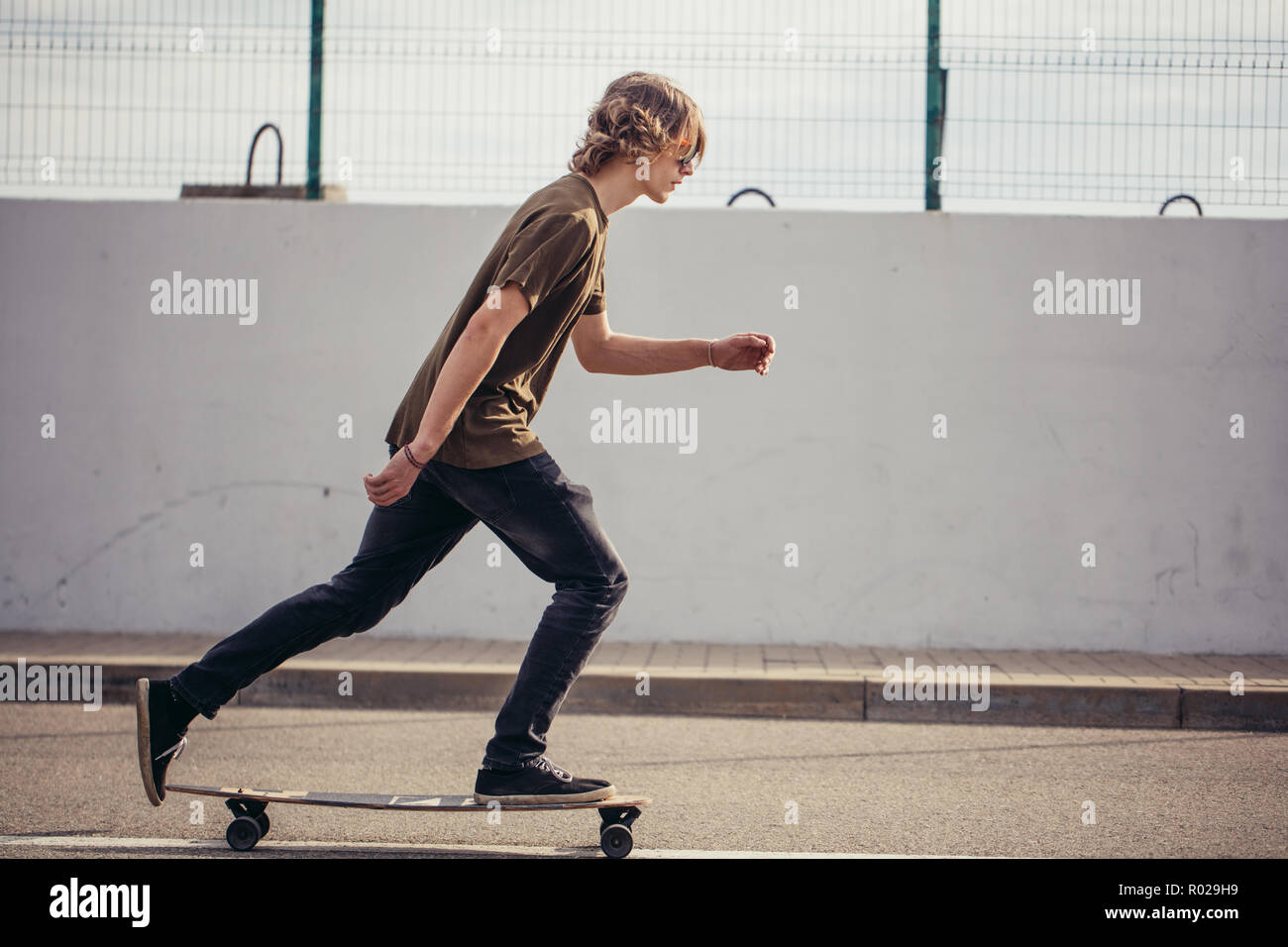 boy riding longboard on boardwalk, warm summer time Stock Photo - Alamy