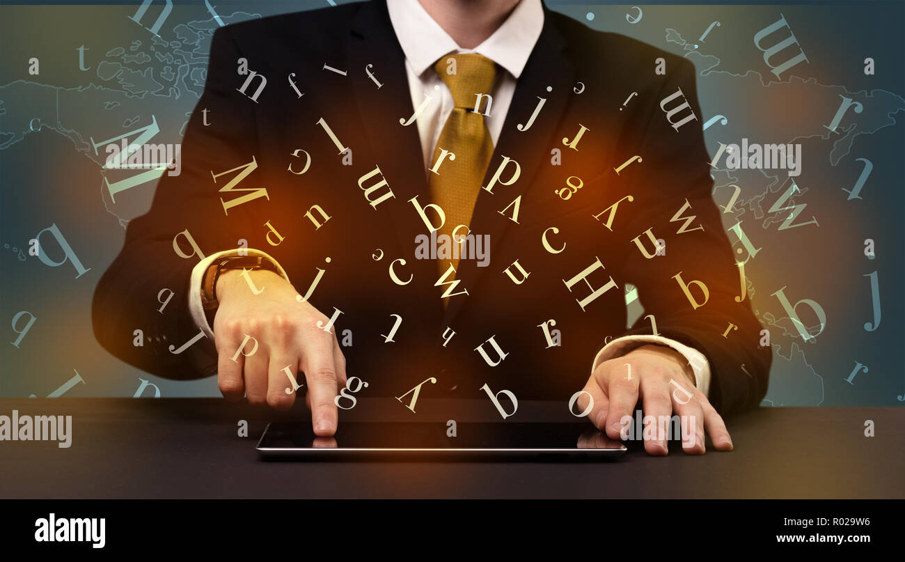 Young man in suit and formal clothing typing with letters around Stock ...