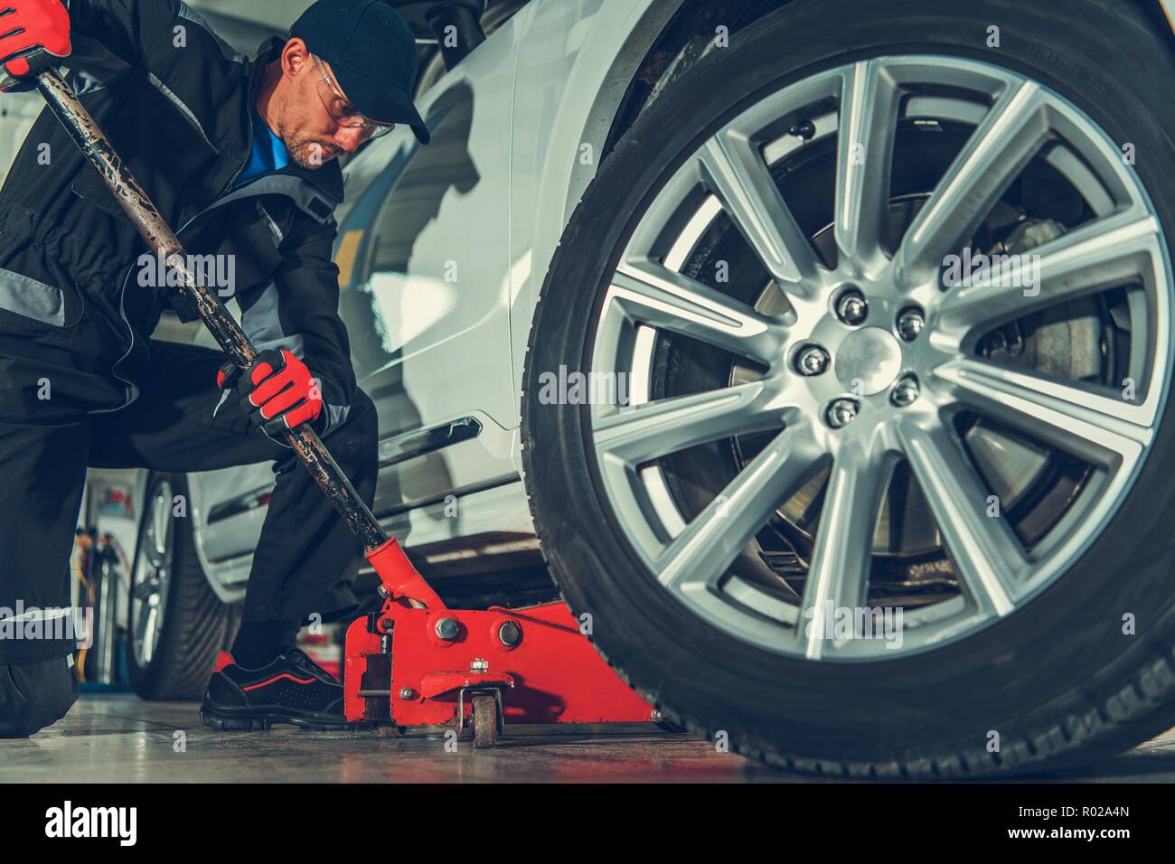 Caucasian Automotive Mechanic with Floor Jack Car Lift. Vehicle ...