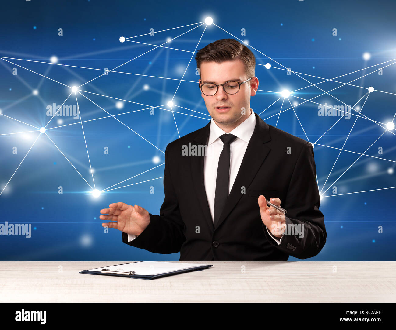 Young handsome businessman sitting at a desk with a blue connection ...