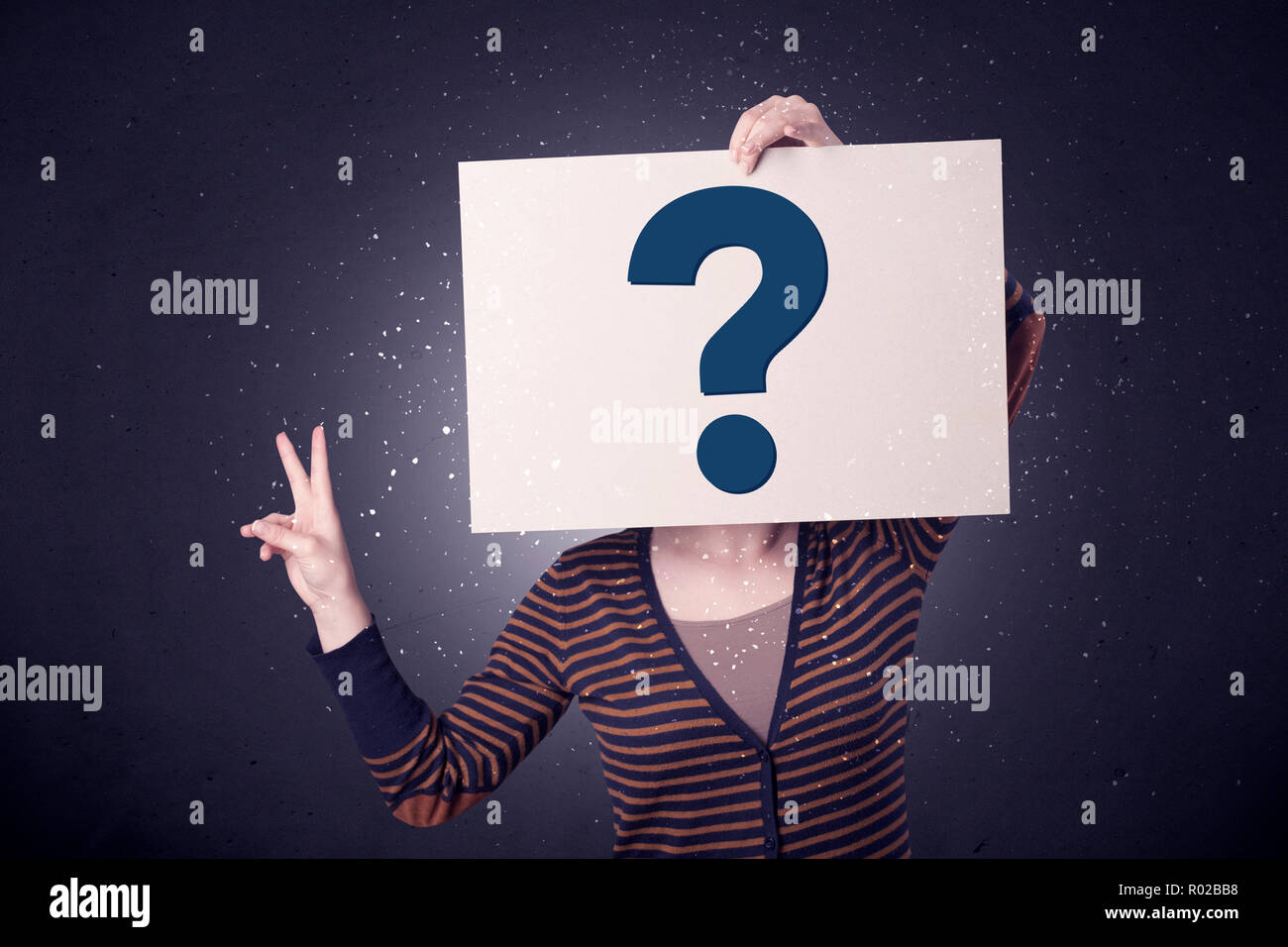 Young casual woman hiding behind a question mark drawn on paper Stock ...