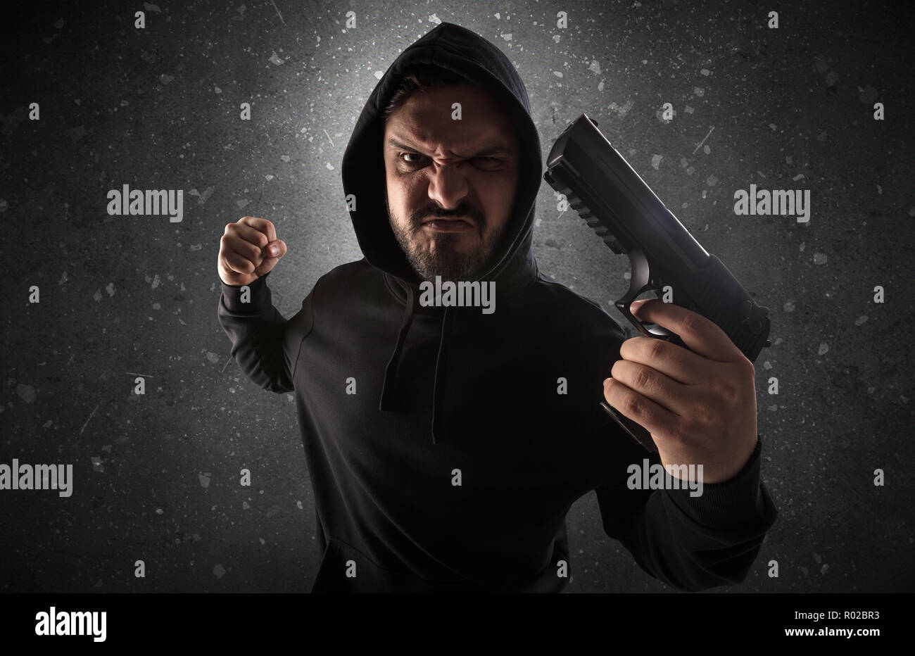 Masked armed villain in empty dark room with gun ax chainsaw mallet ...