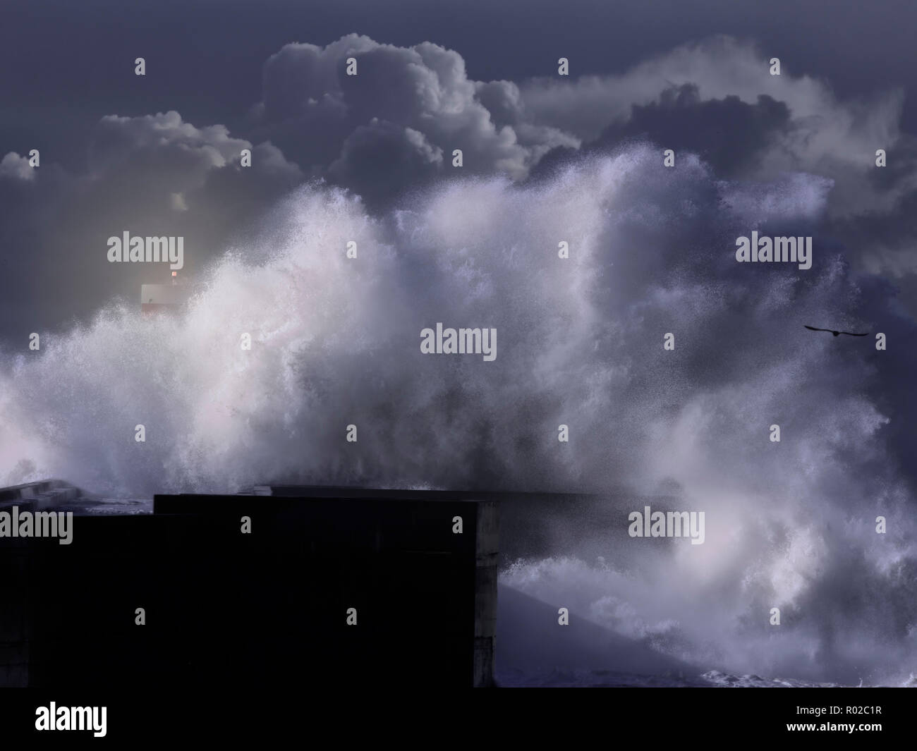 Sea storm at night with pier and beacon covered by dangerous waves ...