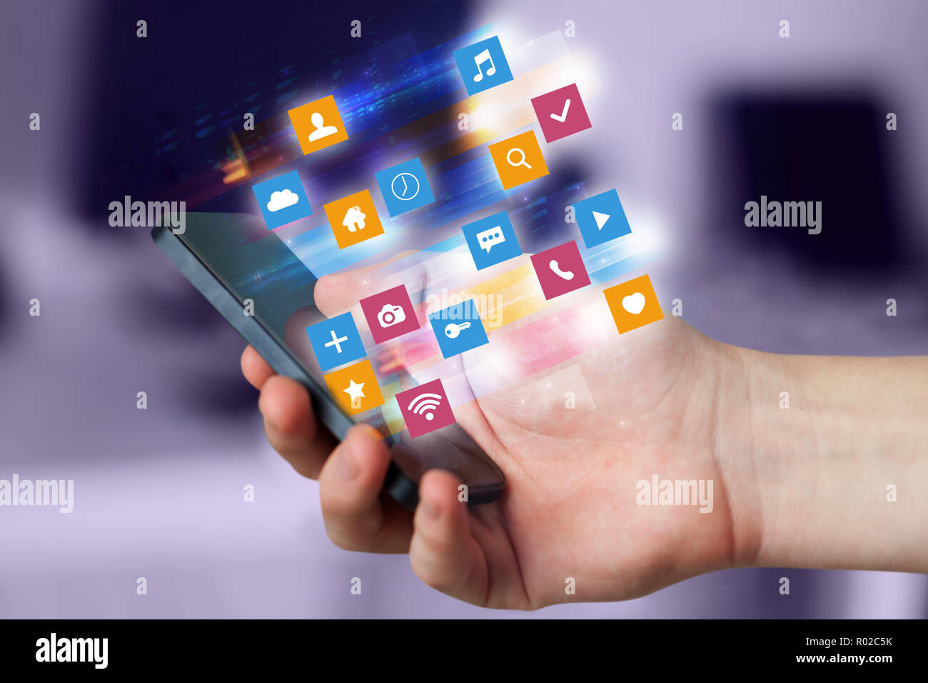 Hand using phone with colorful fast moving application icons and ...