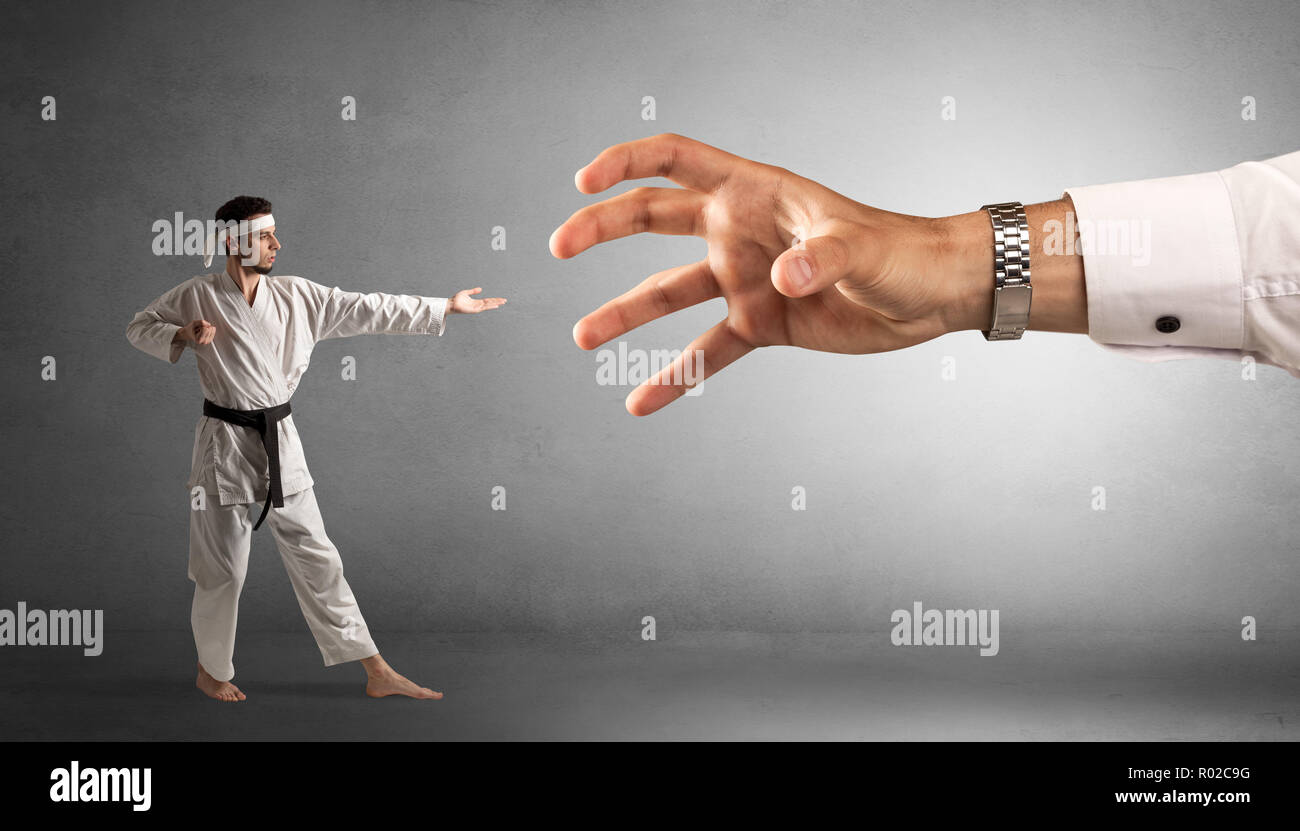 Small karate man fighting with big hand Stock Photo - Alamy