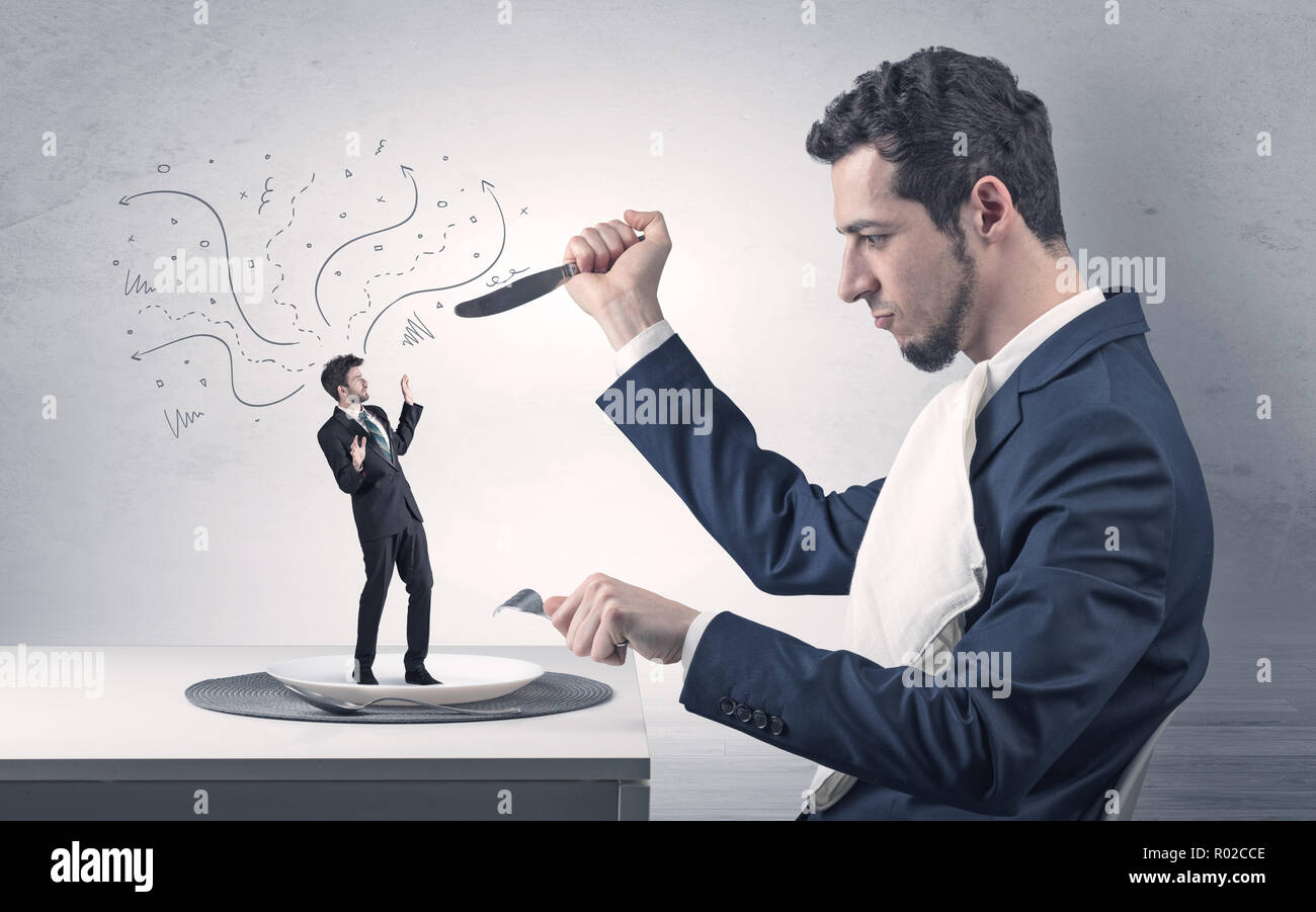 Big boss eating small businessman with knife and fork Stock Photo - Alamy