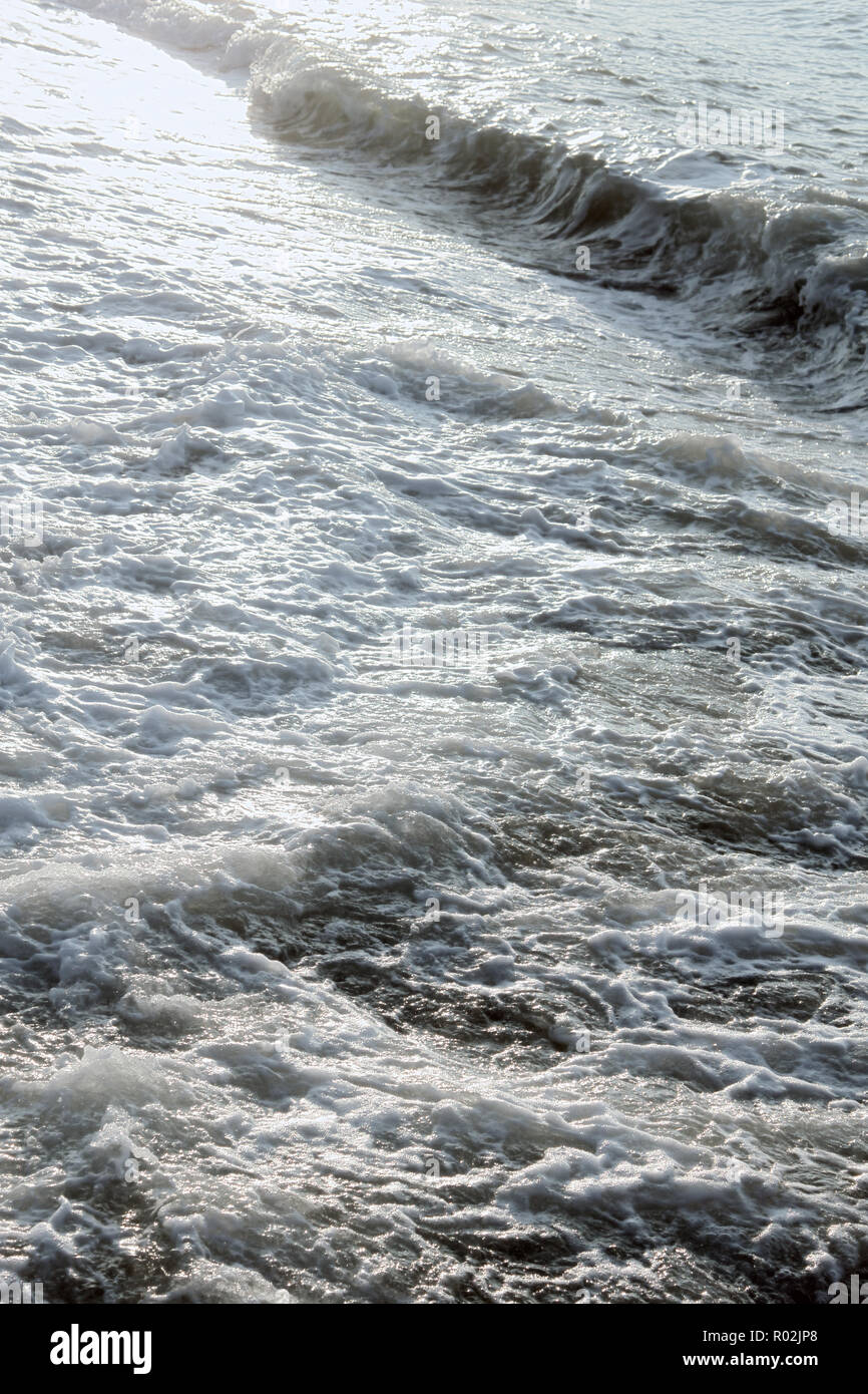 Sea rolling and receding water in rays of setting sun. Black sea ...