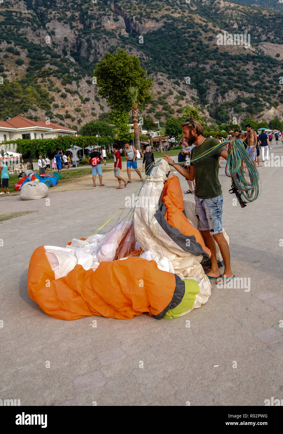 Fethiye, Mugla/Turkey- August 19 2018: Paraglider packing parachute ...