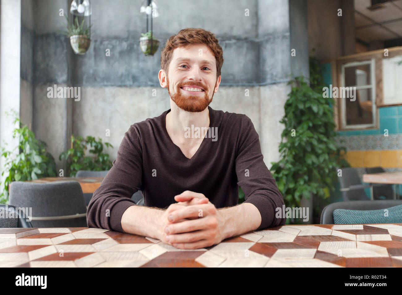 Man beard sitting table looking hi-res stock photography and images - Alamy