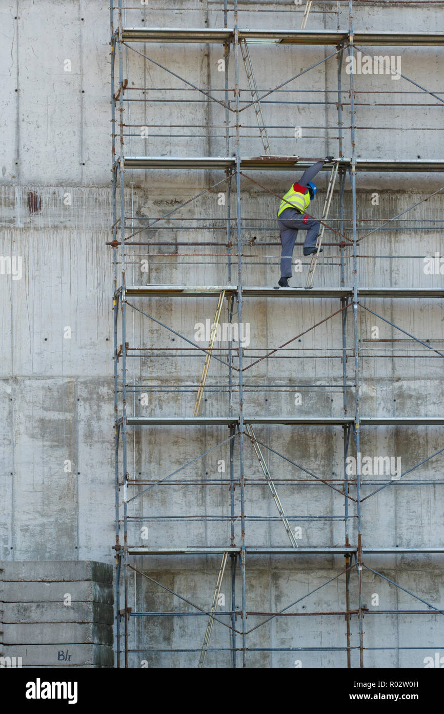 Worker is climbing at the construction in building site Stock Photo - Alamy