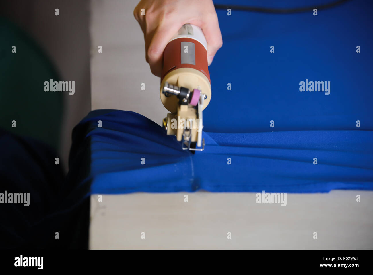 Worker at the factory sketching marks on the cloth. Cutting the cloth ...