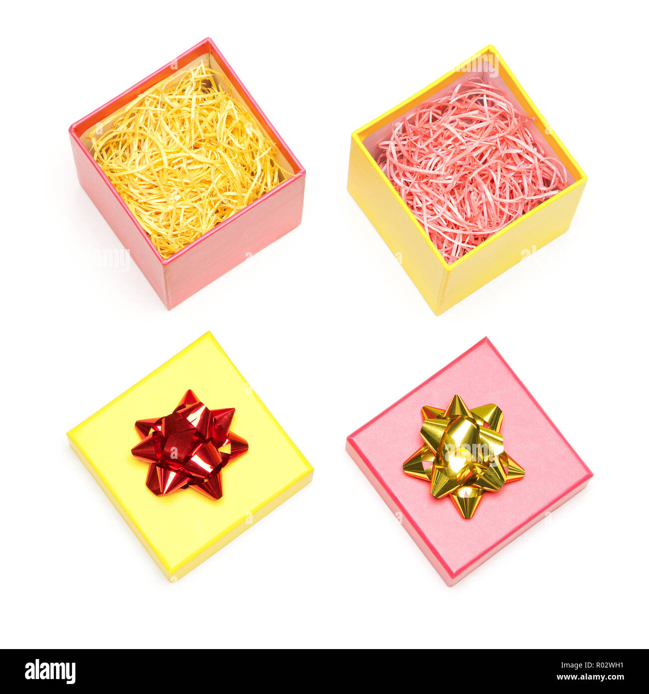 Two open colored gift boxes filled with decorative shavings on white ...