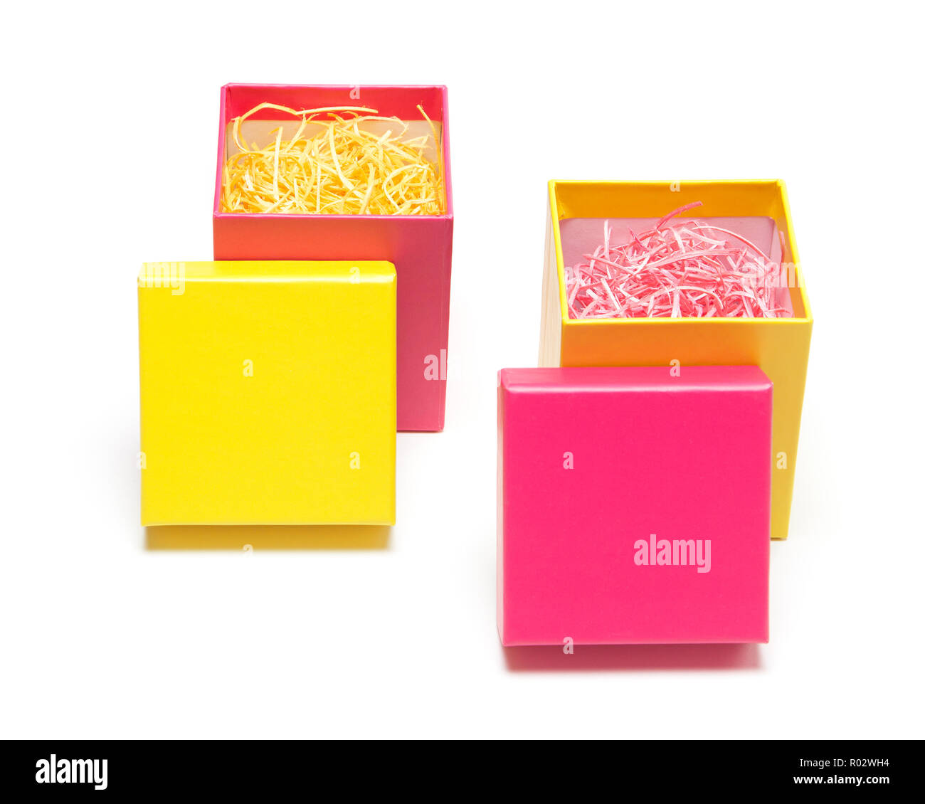 Two open colored gift boxes filled with decorative shavings on white ...
