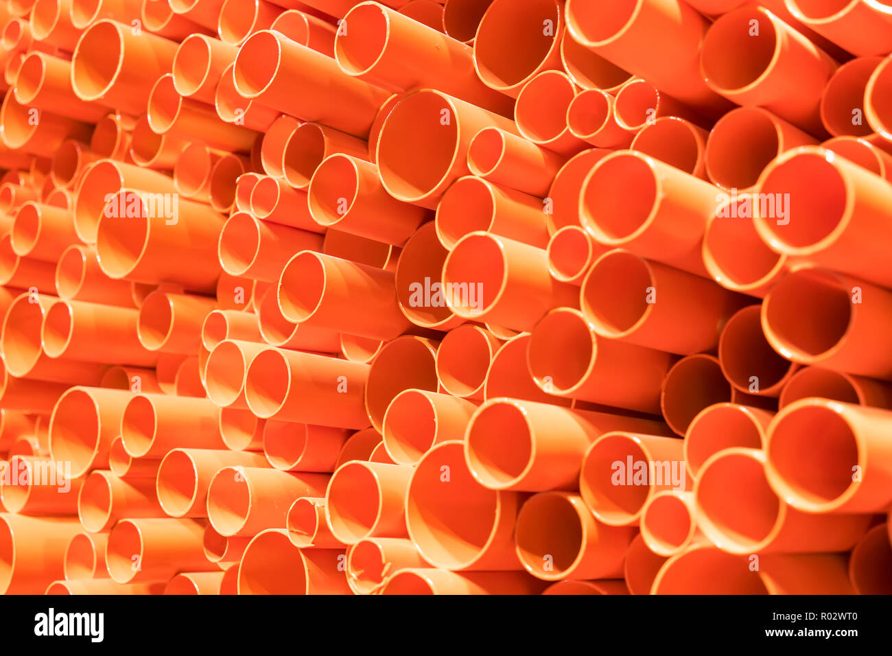 orange PVC pipes stacked in construction site Stock Photo - Alamy