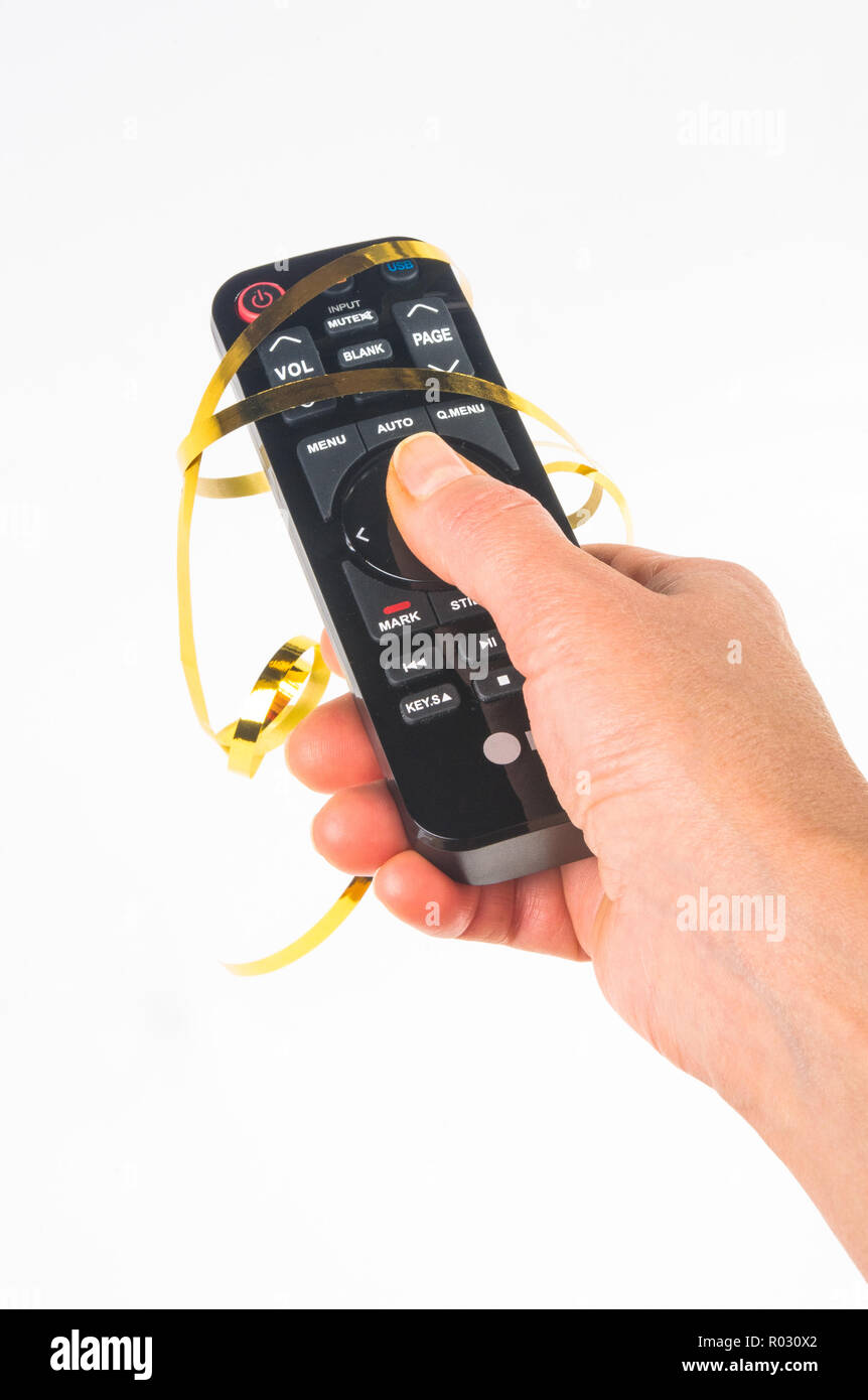 hand holding a remote control in a festive gold ribbon on white ...