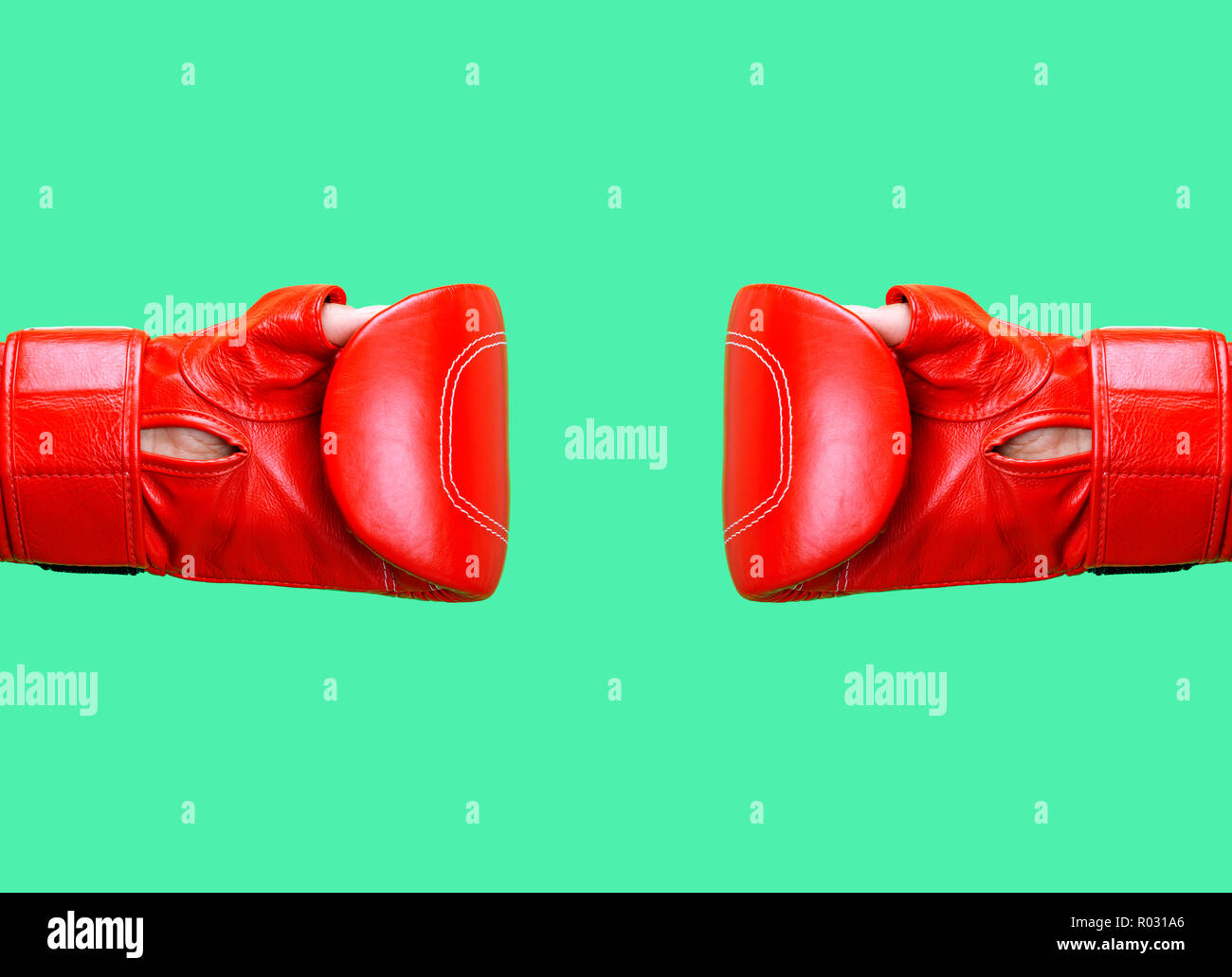 two female hands is wearing a red leather boxing glove on a green ...