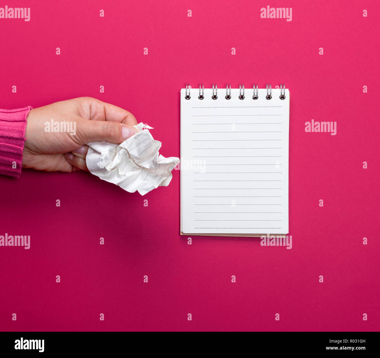female hand holding a white crumpled sheet of paper and an open ...