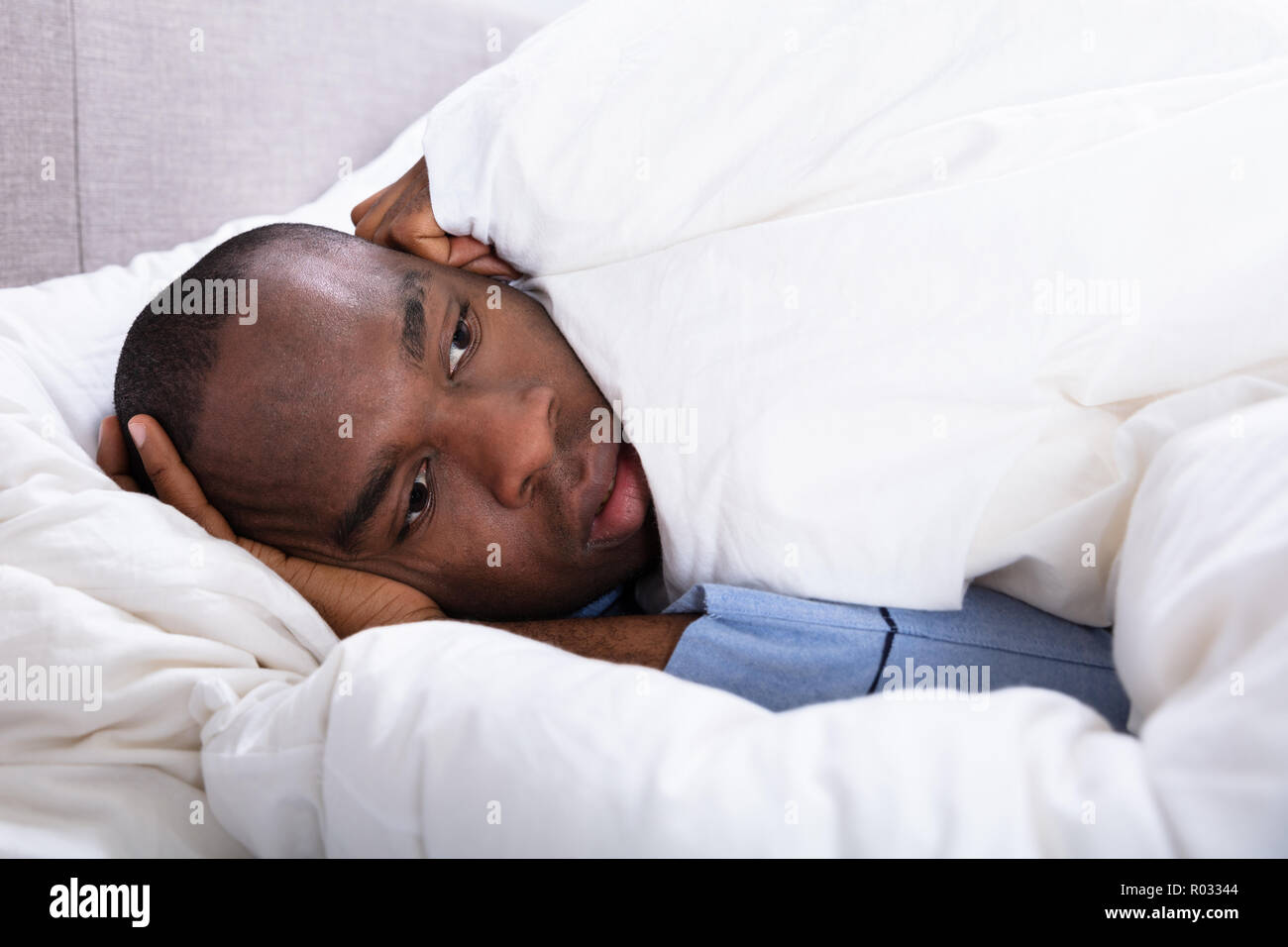 Black man lying on bed hi-res stock photography and images - Alamy