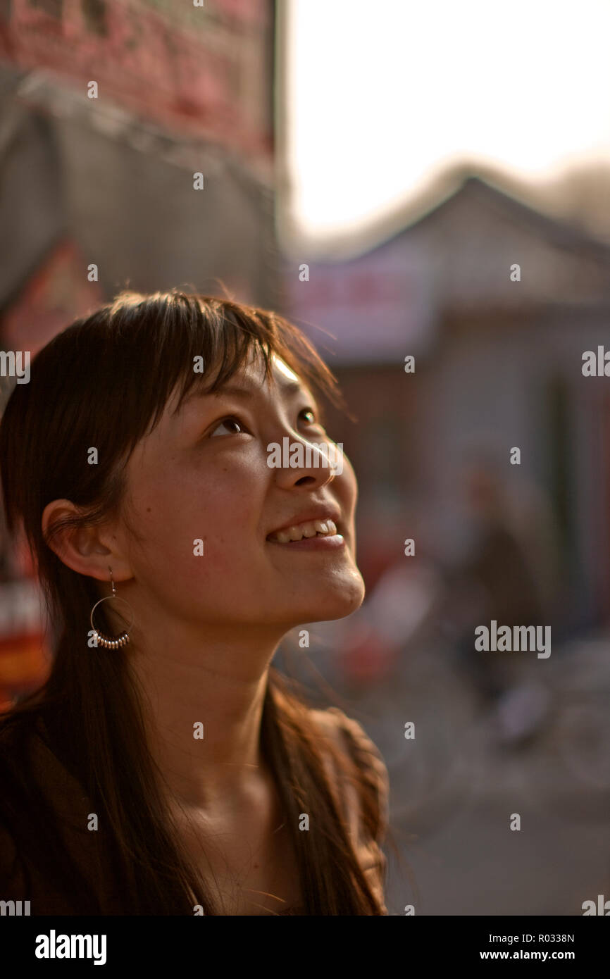 Smiling young woman looking upwards Stock Photo - Alamy