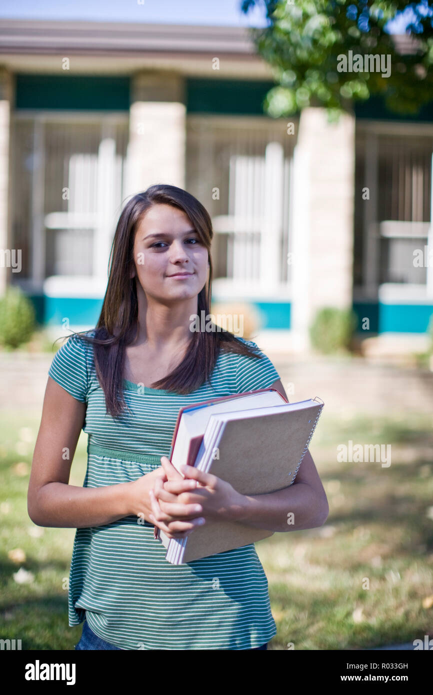 Teenage girl carrying textbooks Stock Photo - Alamy