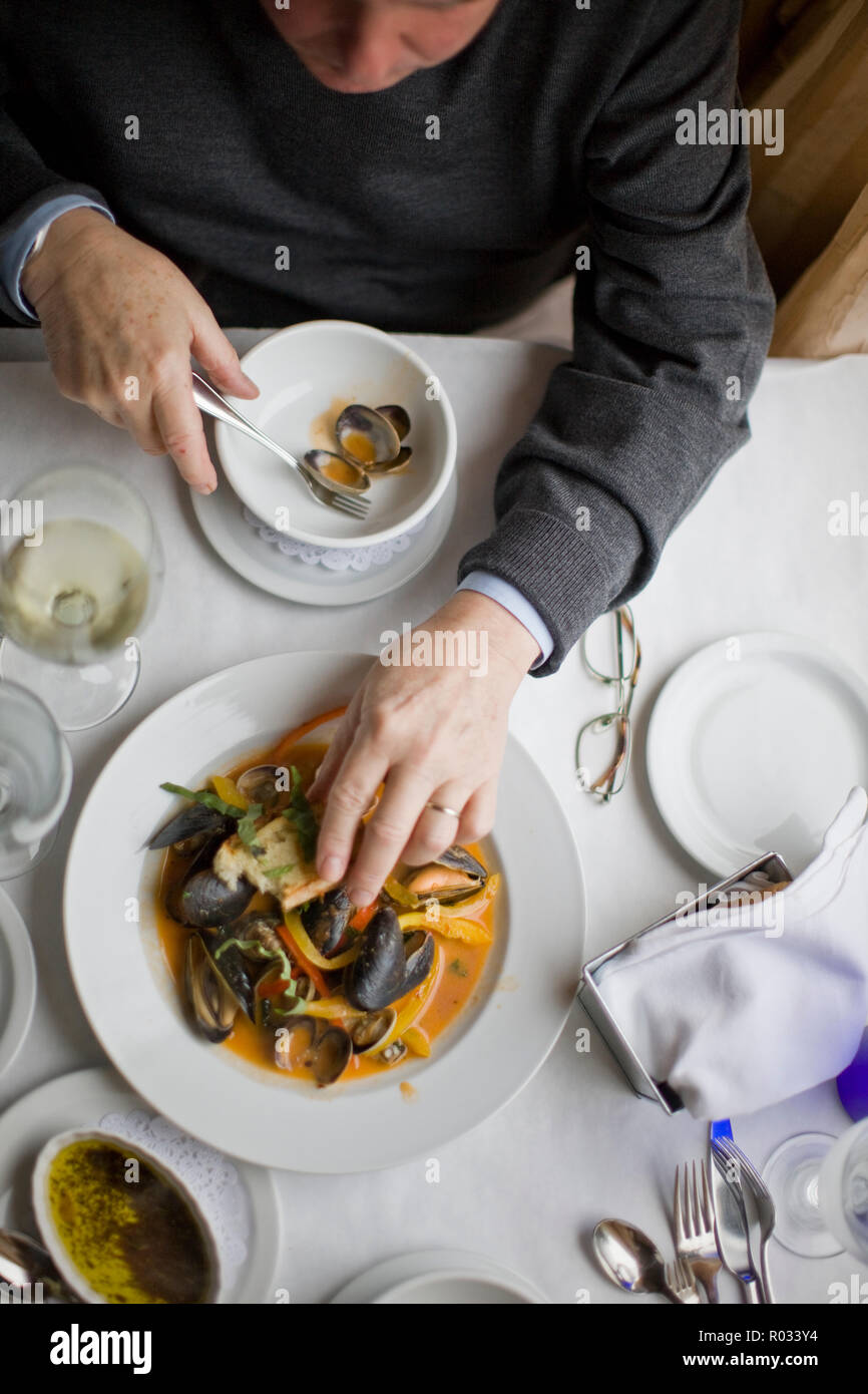 Shellfish being consumed by a mid-adult man in a restaurant Stock Photo ...