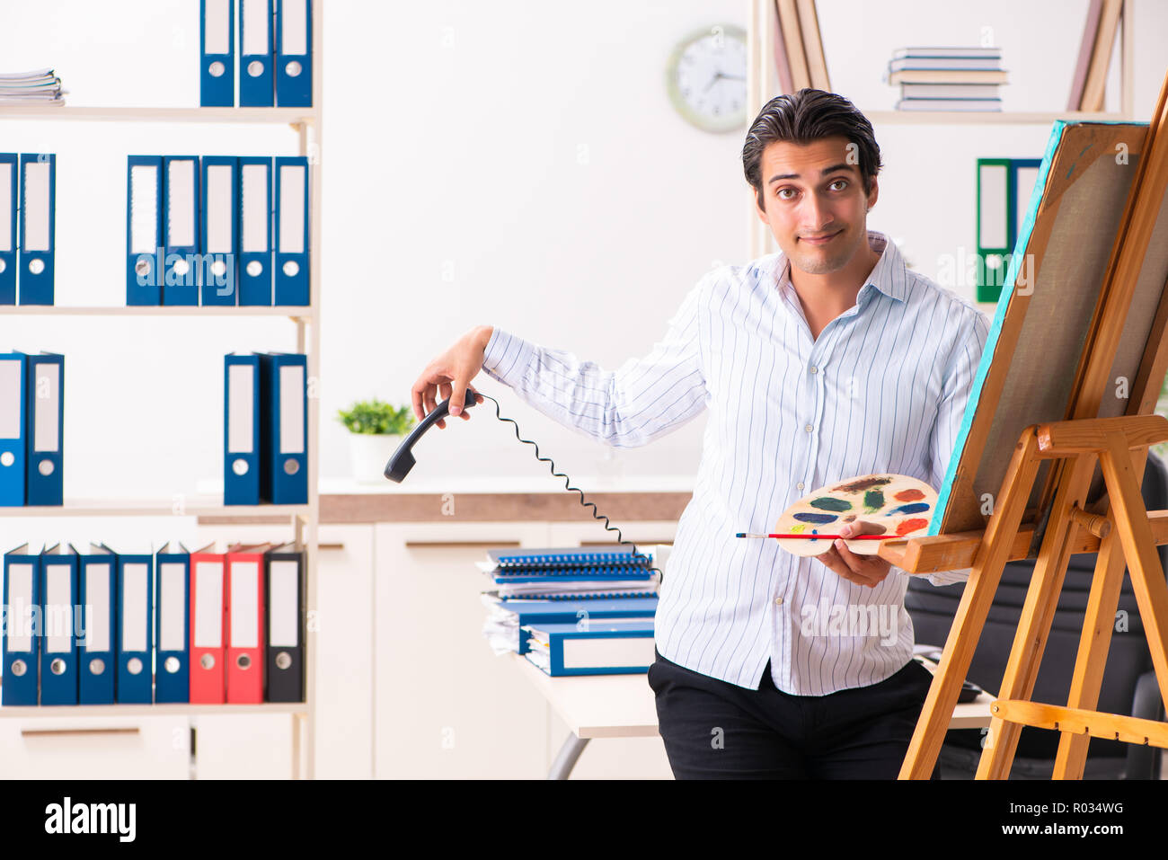 Young handsome employee enjoying painting at the office Stock Photo - Alamy