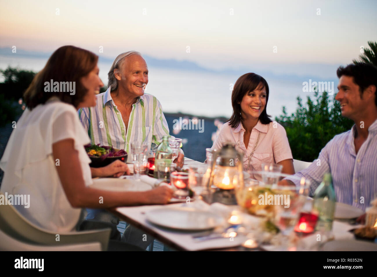 Friends enjoying an outdoor dinner on their back deck Stock Photo - Alamy