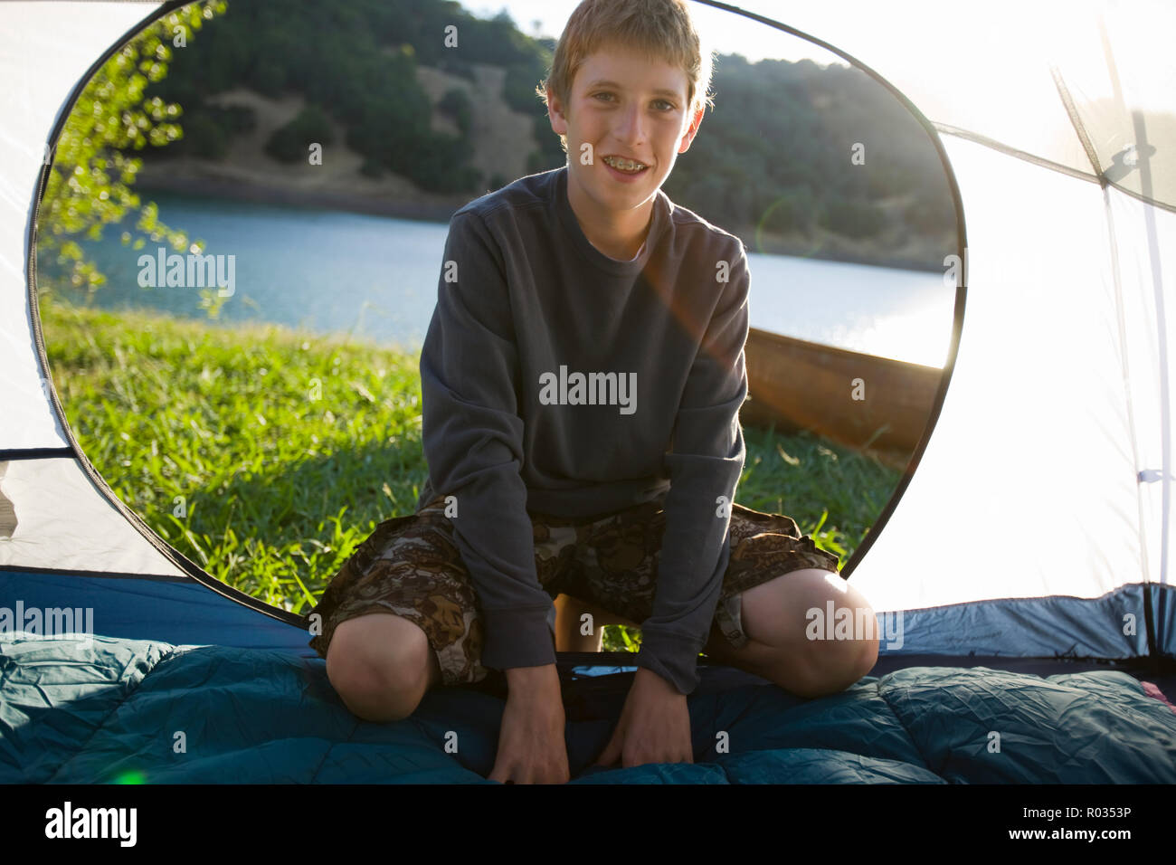 Portrait of a smiling boy sitting inside a tent Stock Photo - Alamy