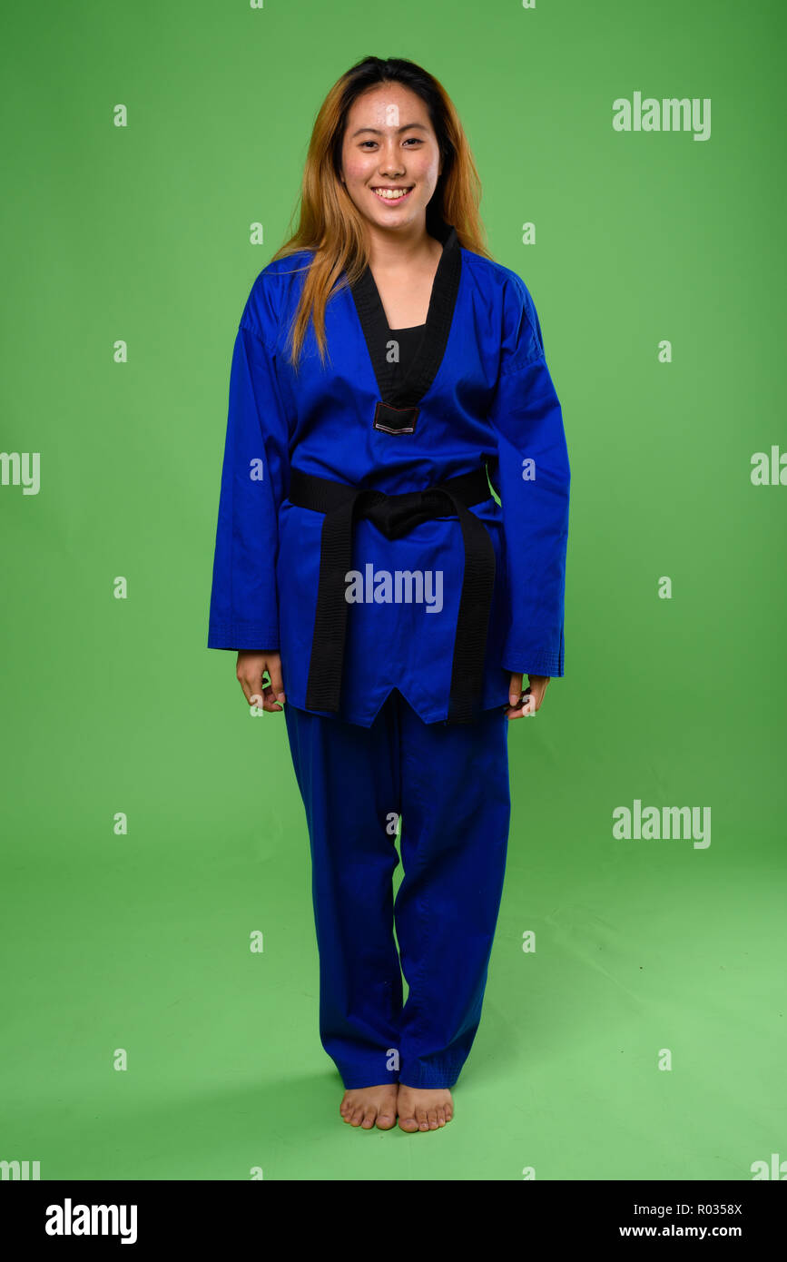 Young Asian woman wearing blue karate Gi against green backgroun Stock ...