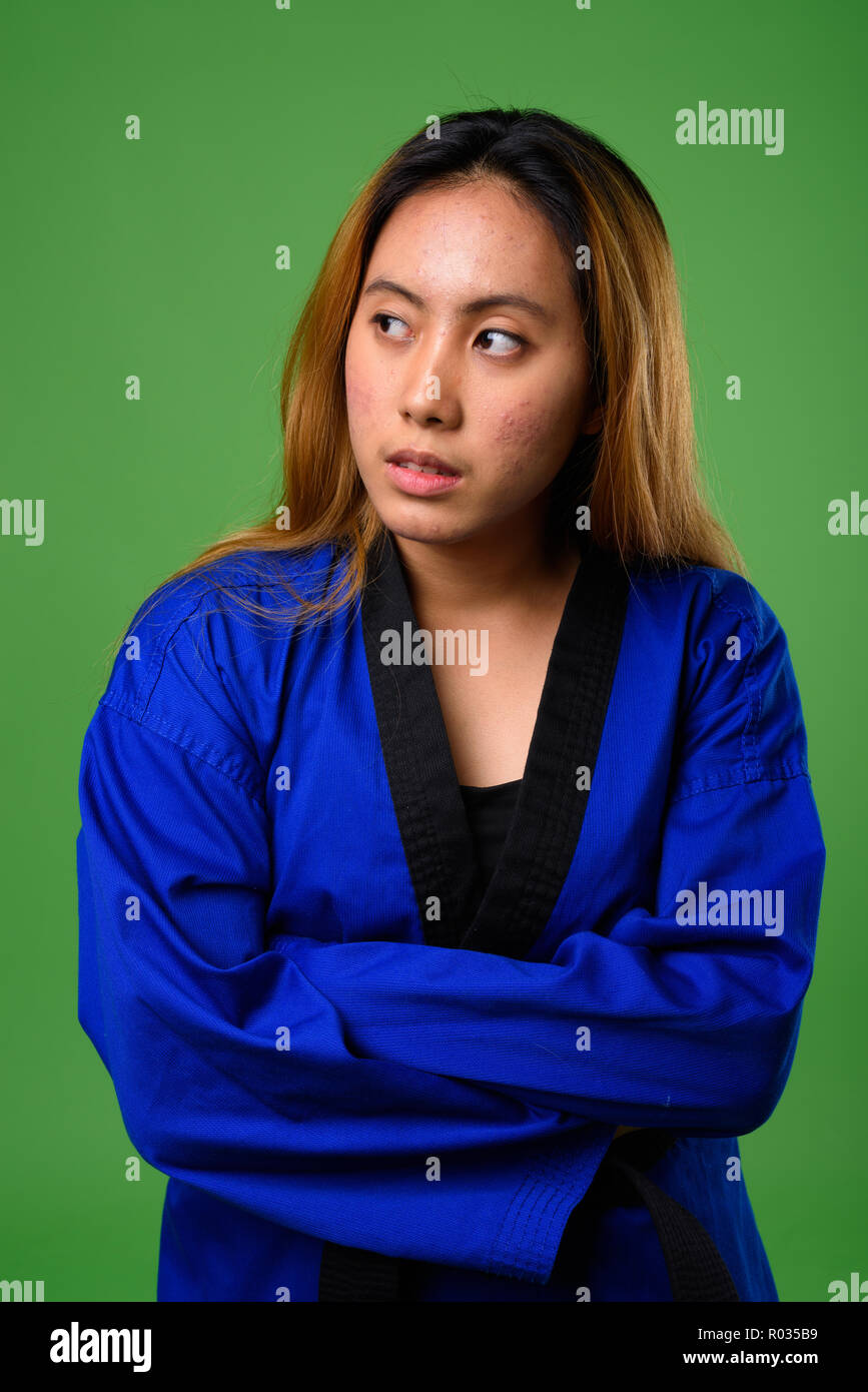 Young Asian woman wearing blue karate Gi against green backgroun Stock ...