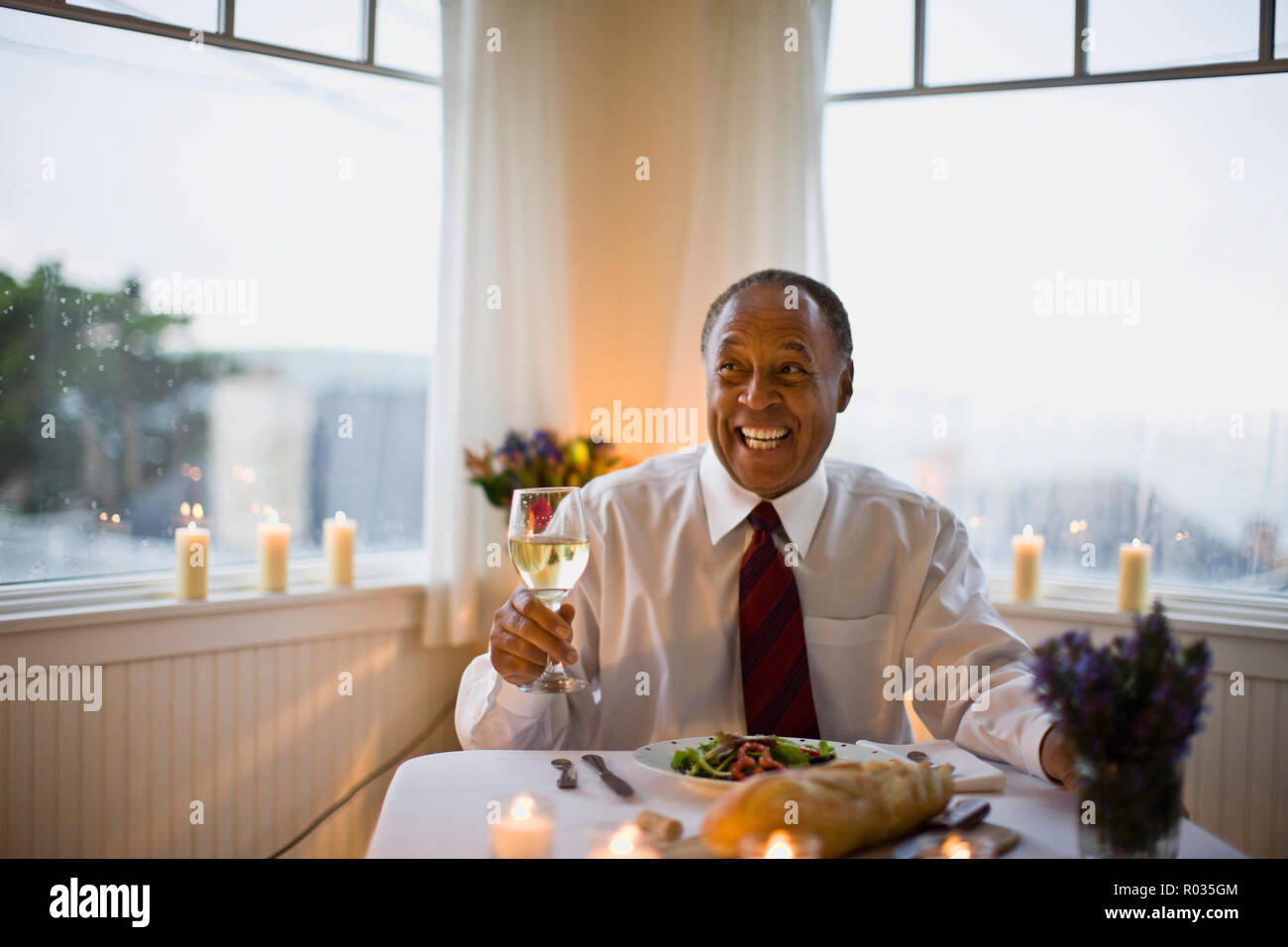 Elderly man laughing at dinner table hi-res stock photography and ...