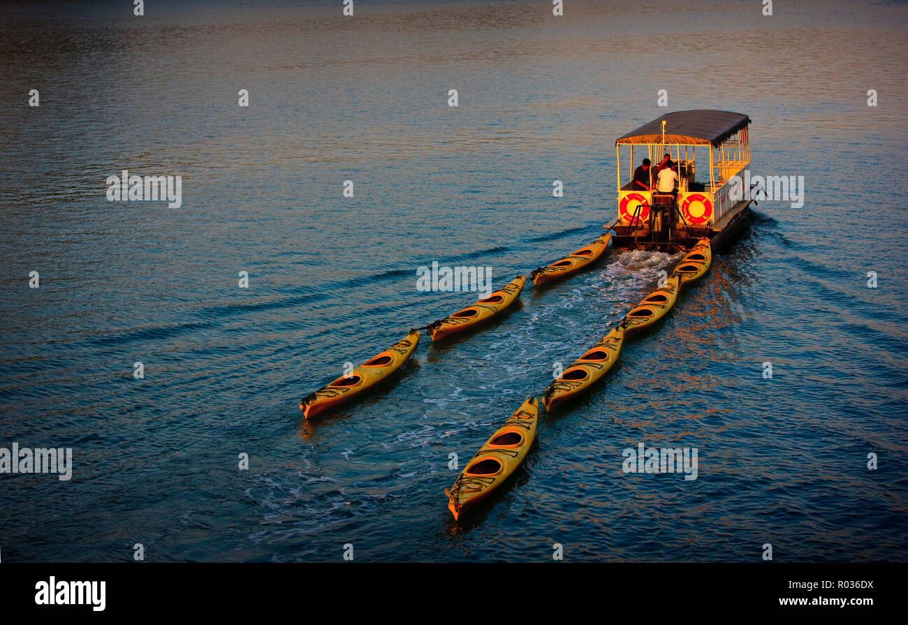 Boat towing kayaks Stock Photo - Alamy
