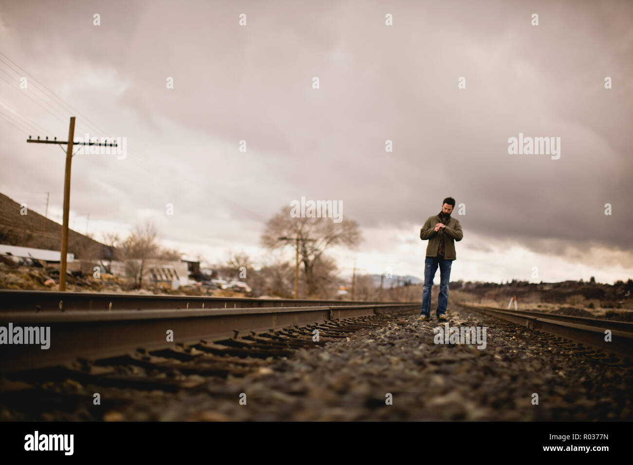 Man standing alone on train tracks Stock Photo - Alamy