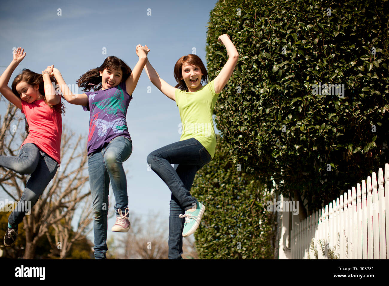 Three friends jumping in the street and having fun together Stock Photo ...