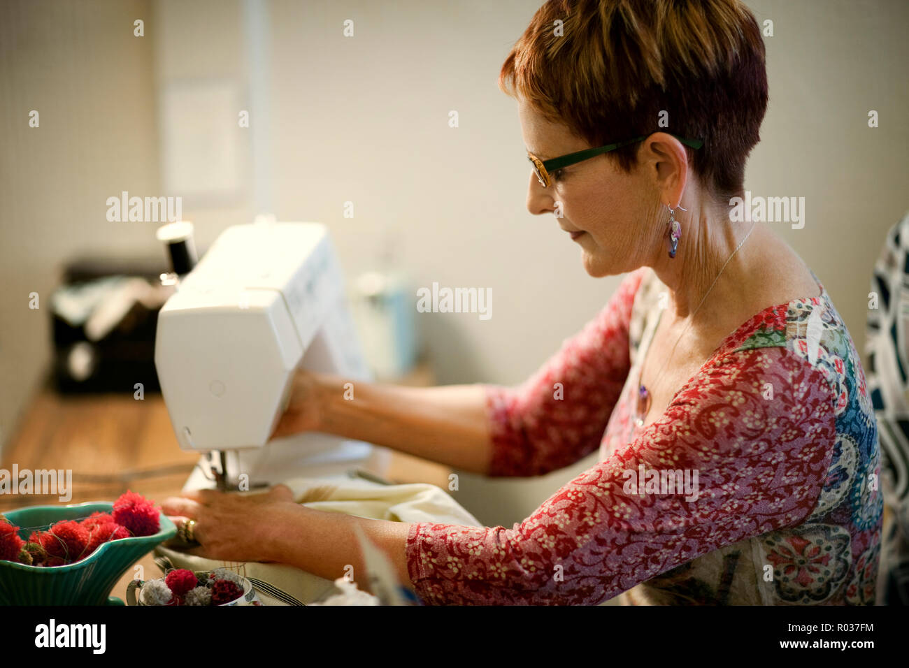 Middle aged woman using a sewing machine Stock Photo - Alamy