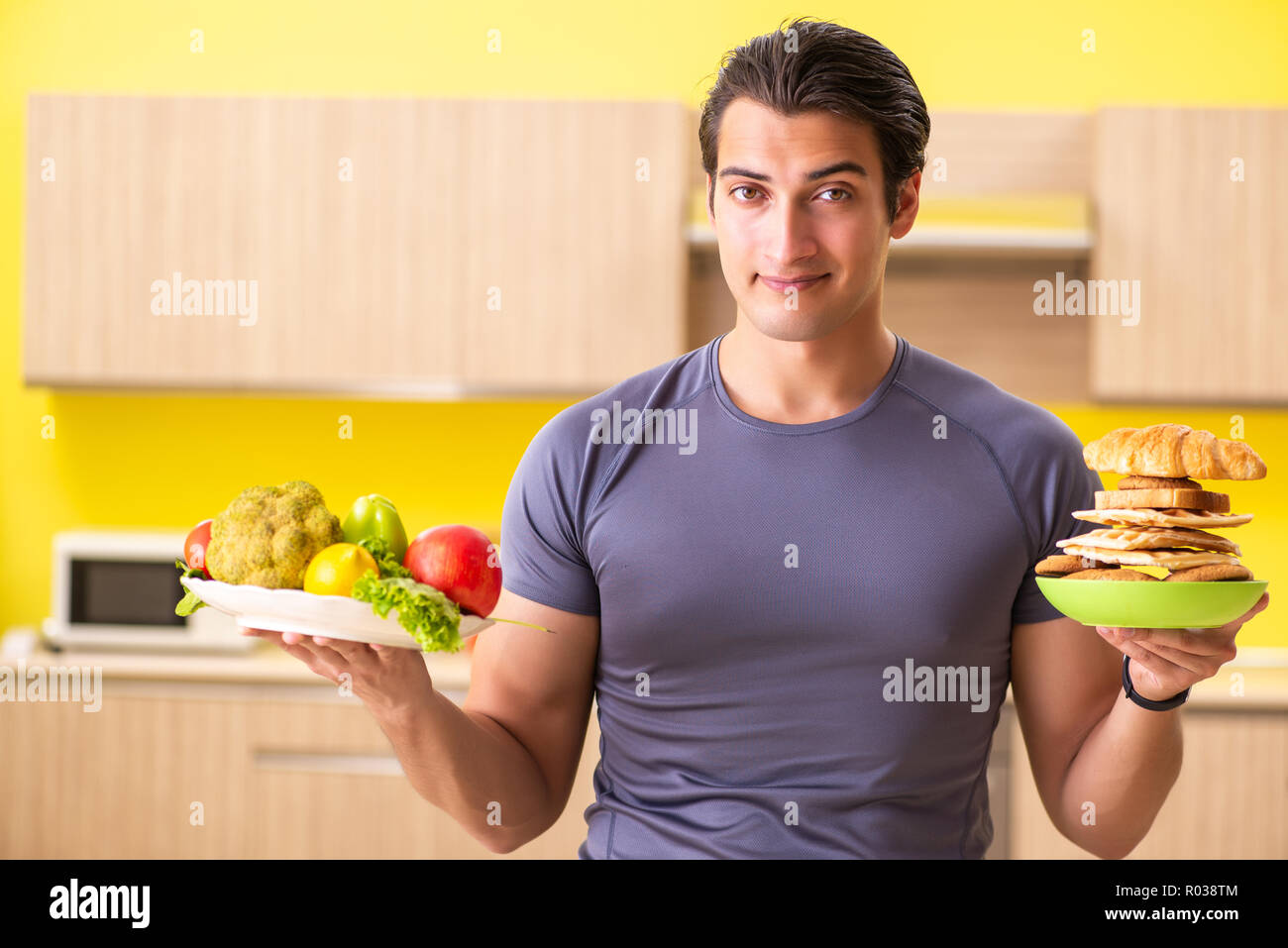 Man having hard choice between healthy and unhealthy food Stock Photo ...