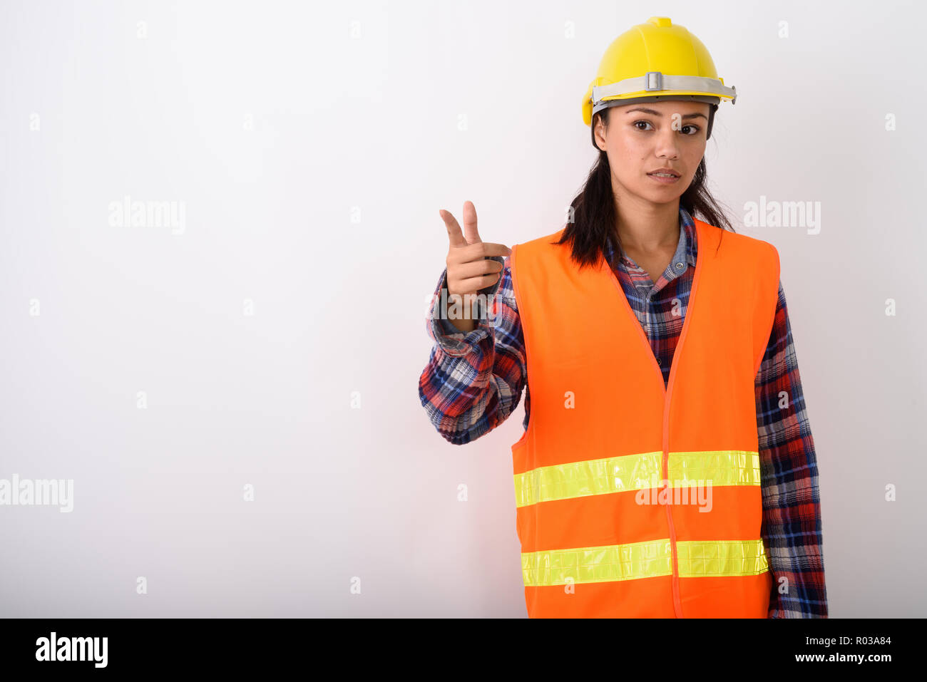 Studio shot of young Asian woman construction worker pointing to Stock ...